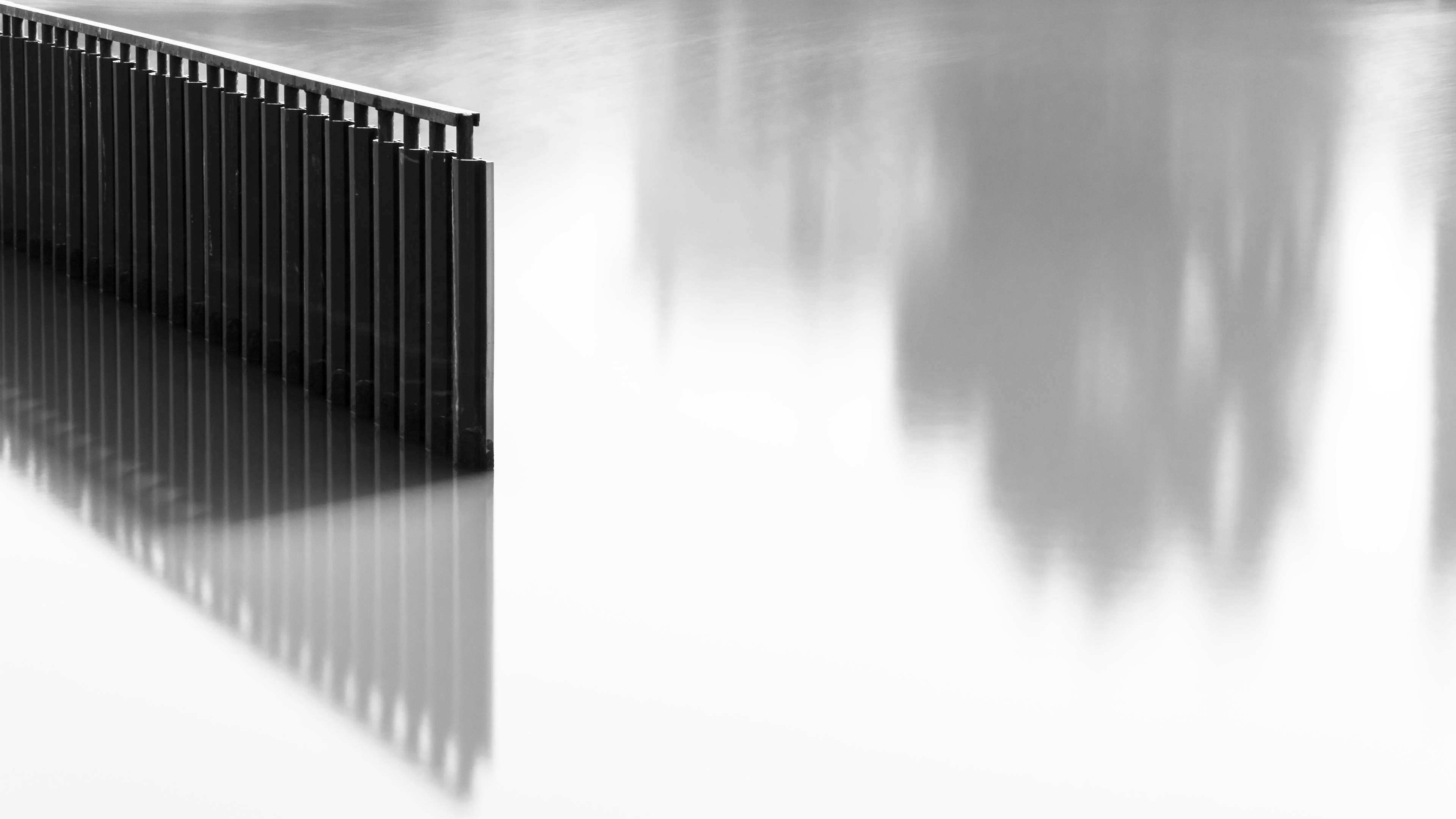 Shoreline Barriers: Parallel Shadows on Quiet Water