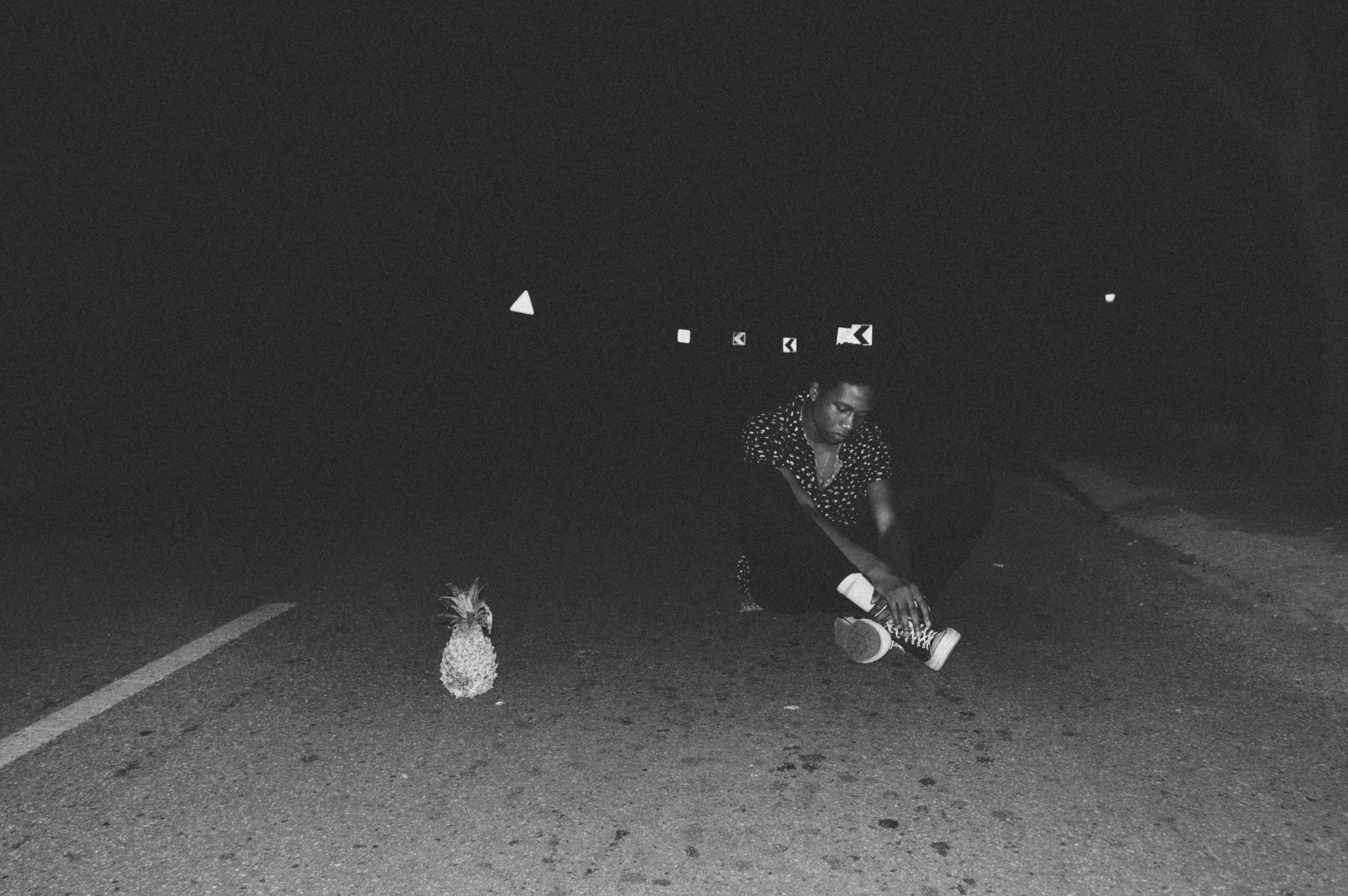 Dim Road, Quiet Witness: A Nighttime Moment with Person and Cat