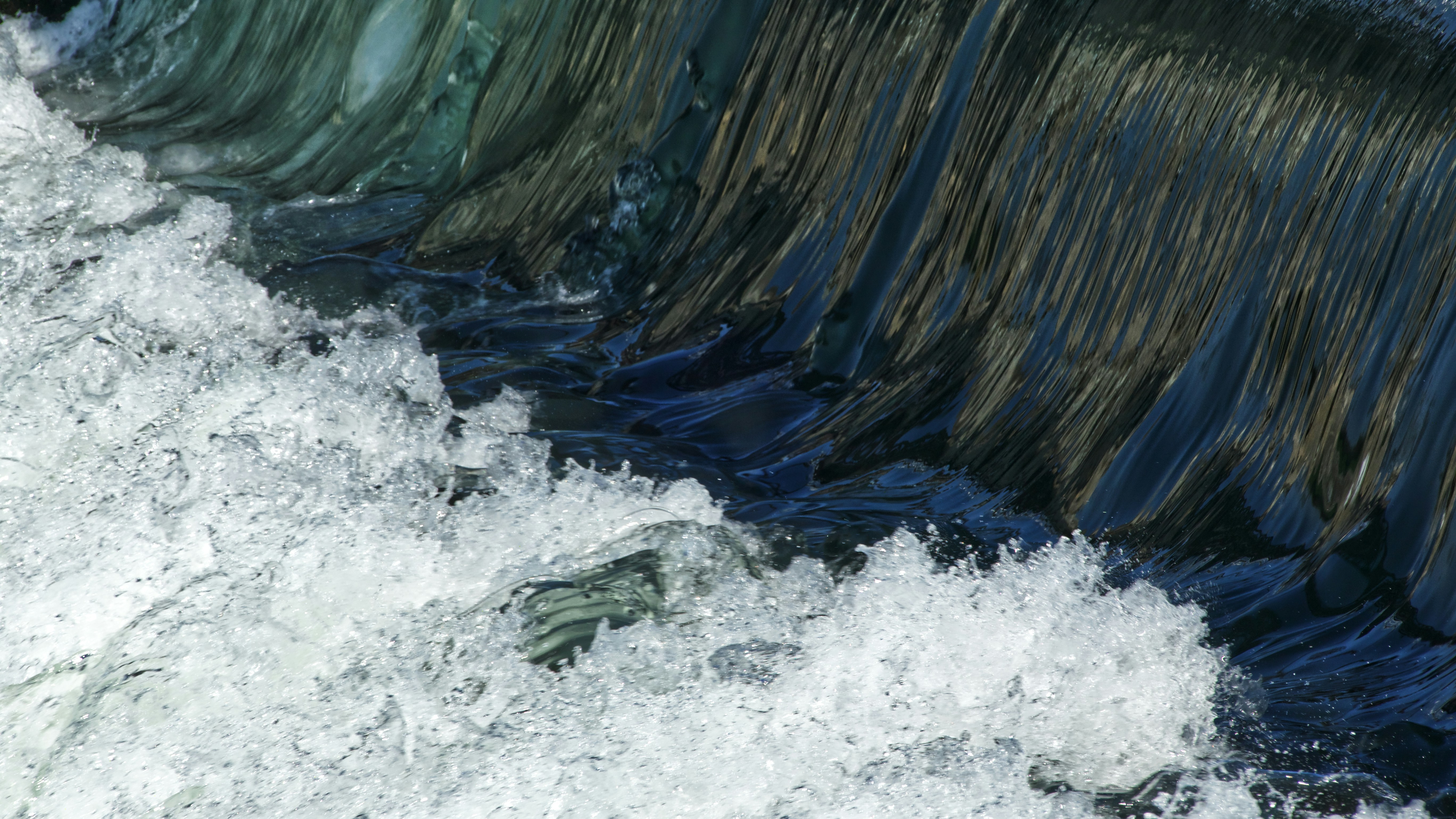 Foam Boundary: Diagonal Lines of Sea Foam Against a Weathered Barrier