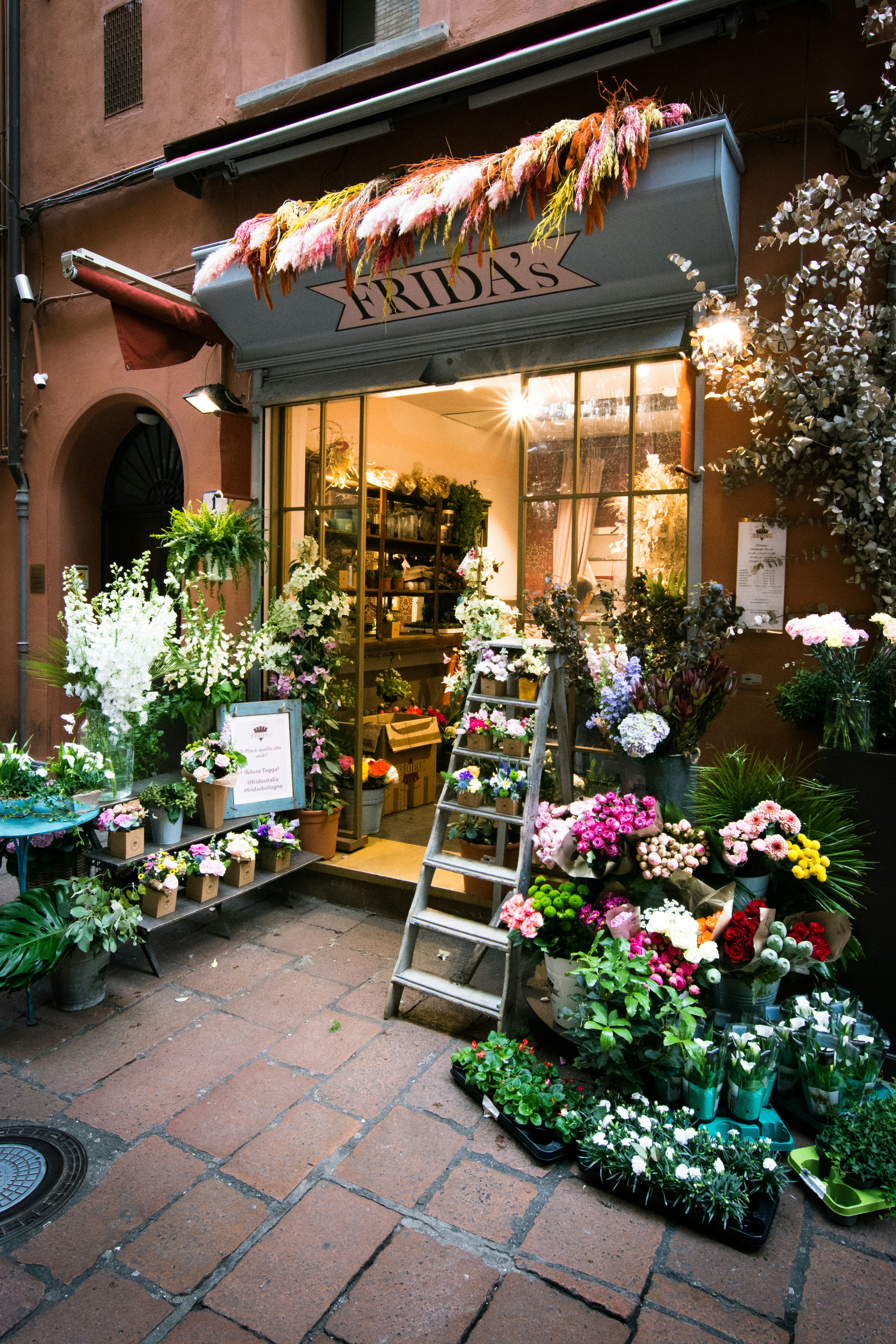 Charming flower shop entrance adorned with vibrant blooms and greenery, inviting passersby to explore its floral offerings.