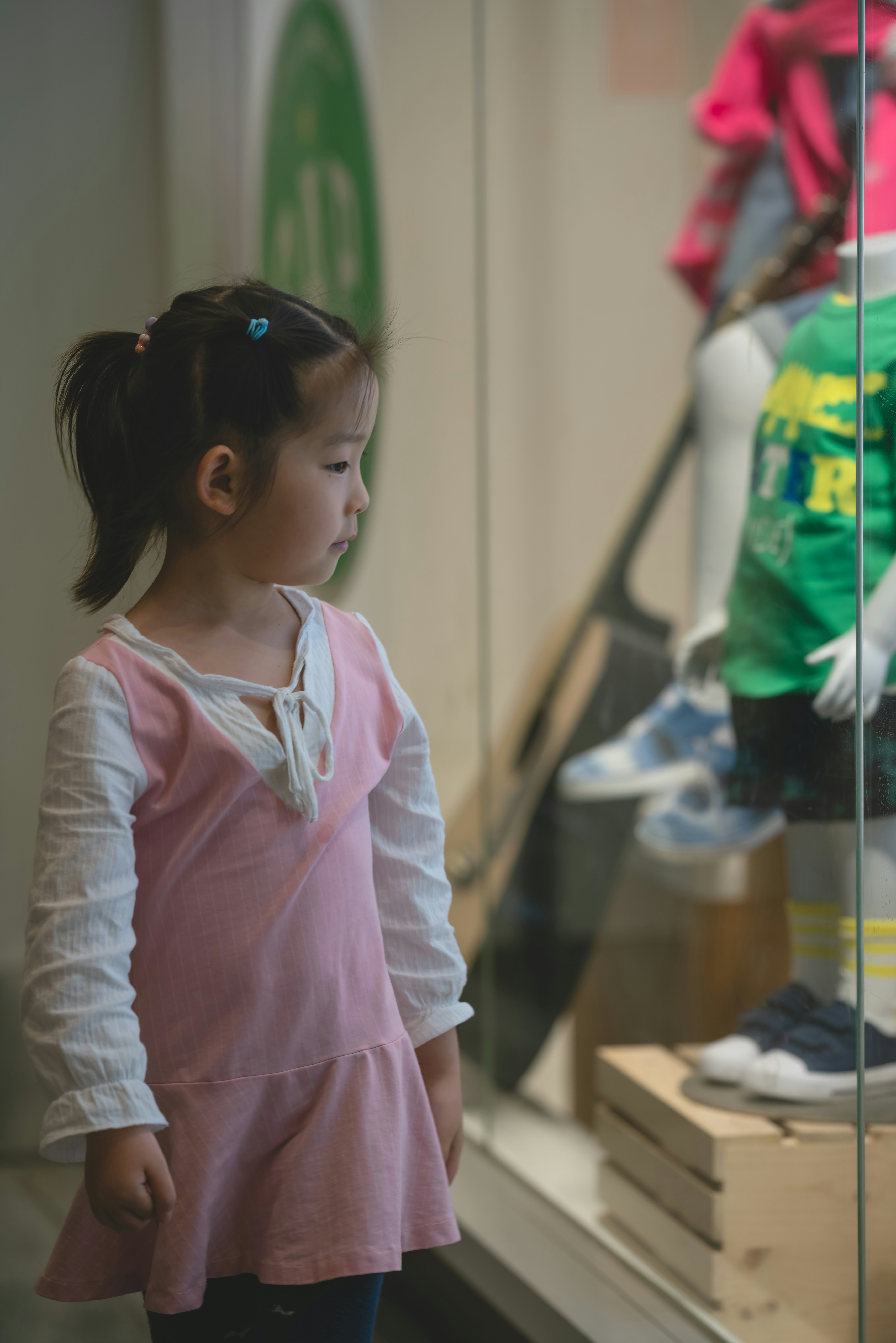 Soft Stare: A Young Girl Gazes Toward a Colorful Display