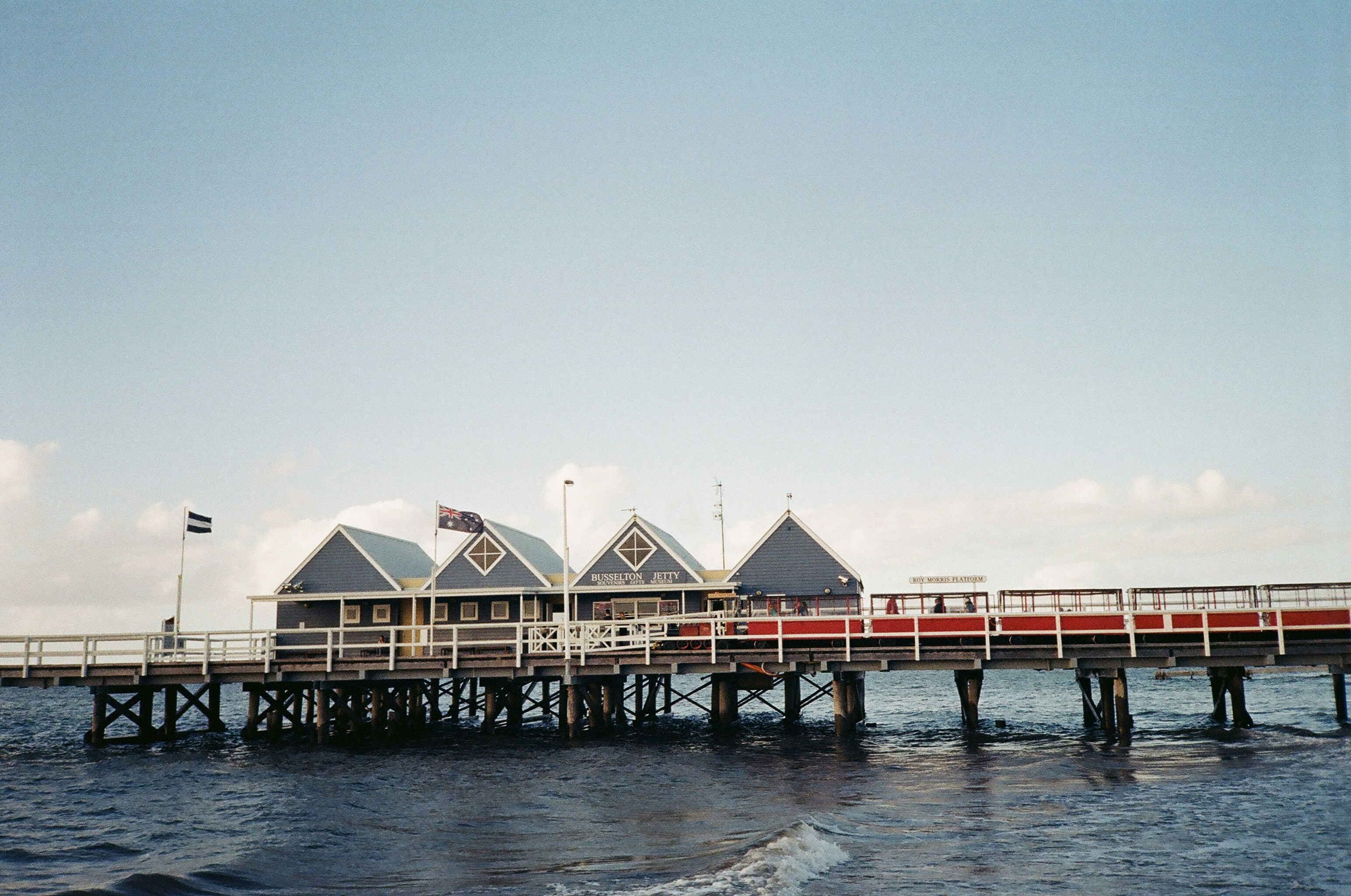 Sunlit Pier Cabins Over a Quiet Blue Expanse