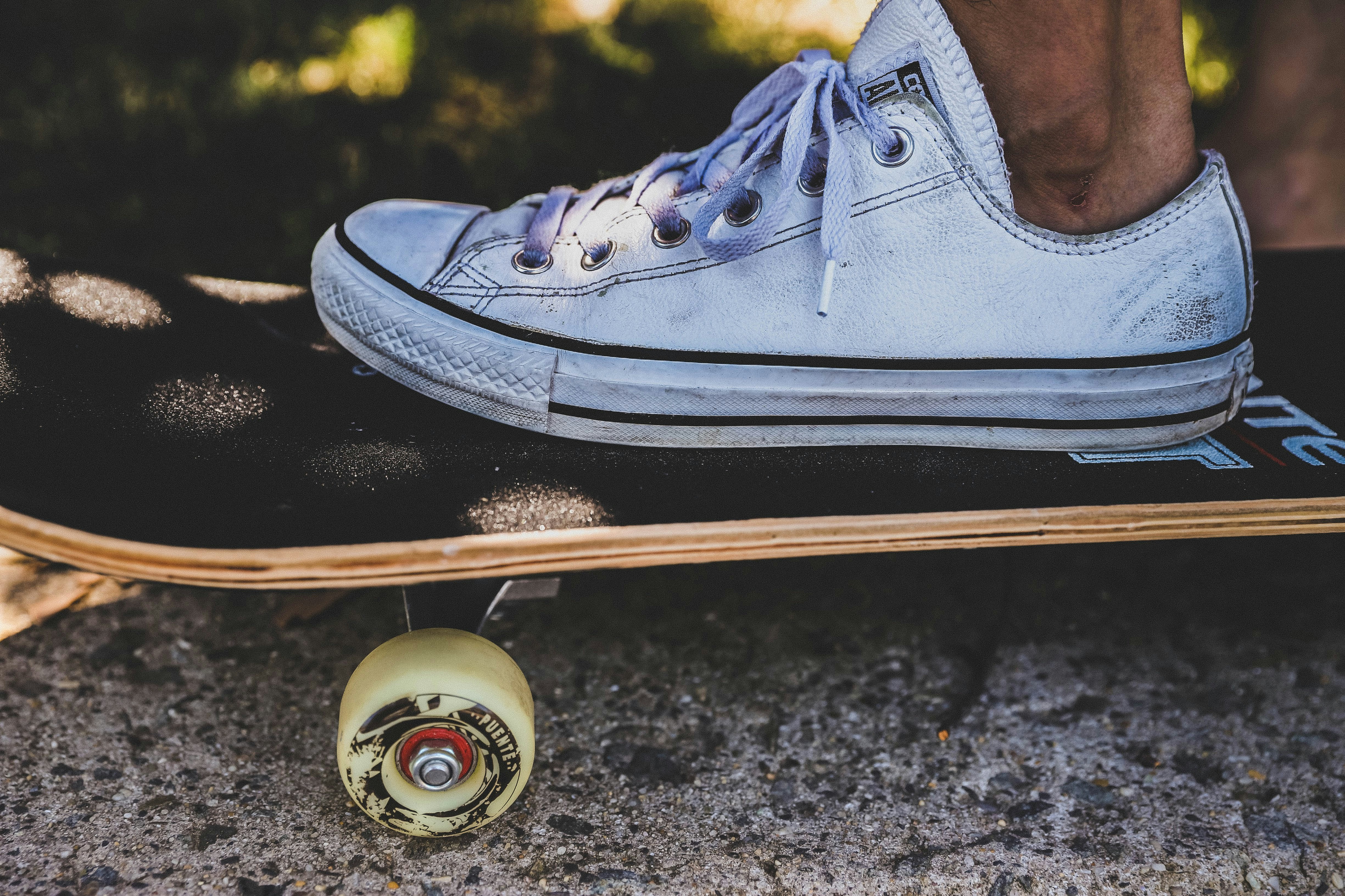 White sneaker on a skateboard: a close-up of the momentary balance between foot and board