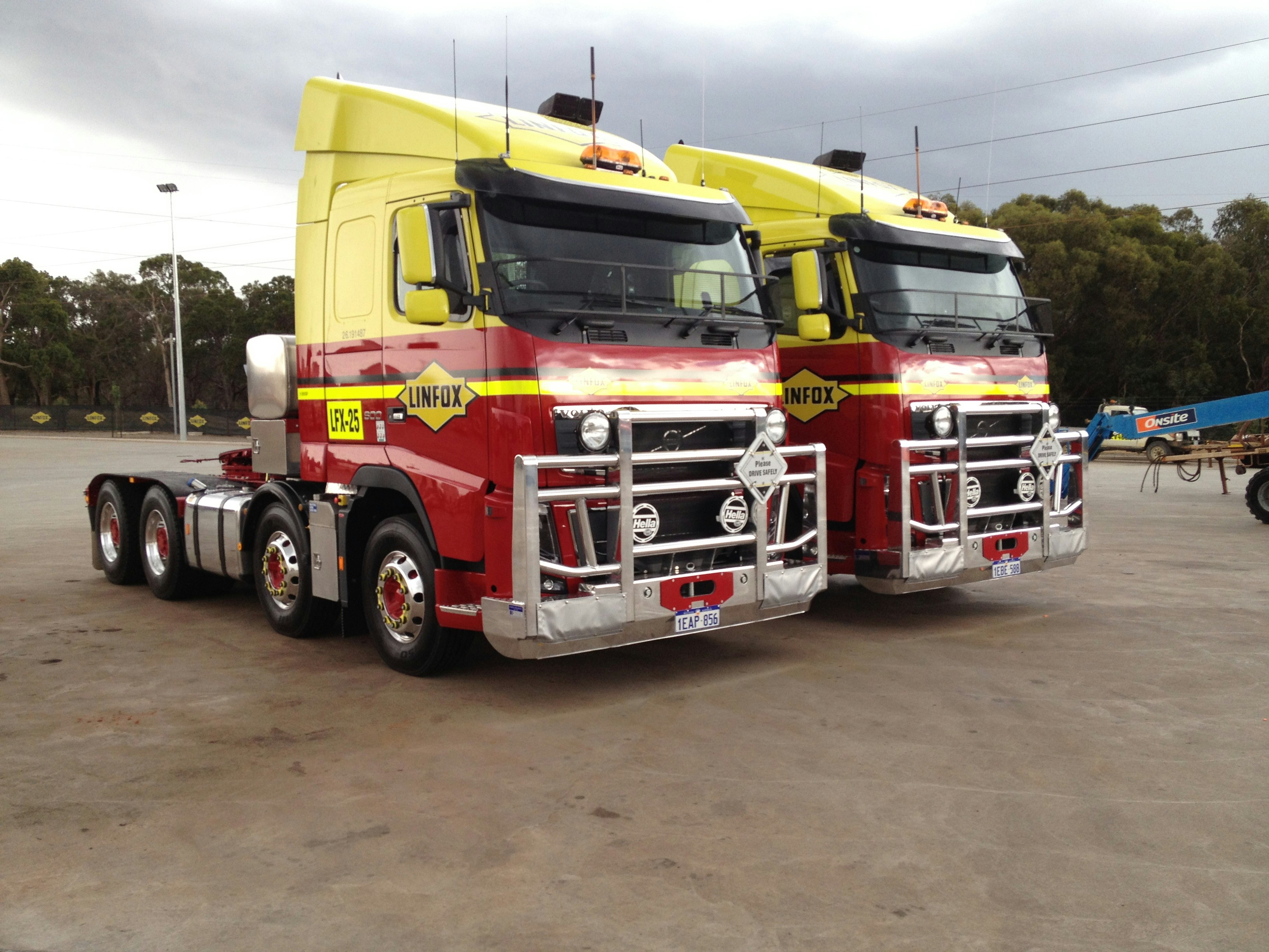 Two red-and-green semi trucks parked at road photo – Free Australia ...