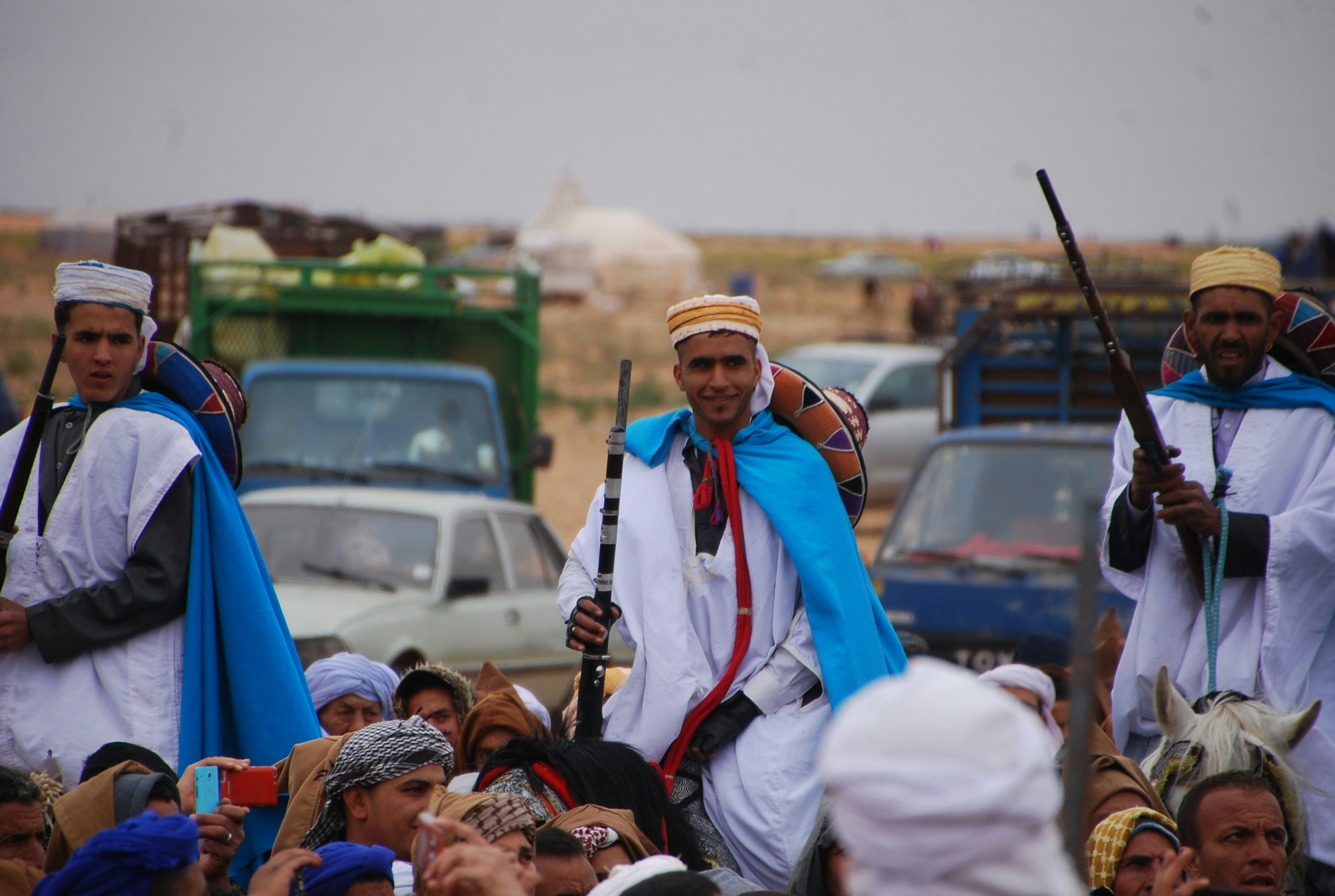 People holding rifle by a crowd of sitting people photo – Free Car ...
