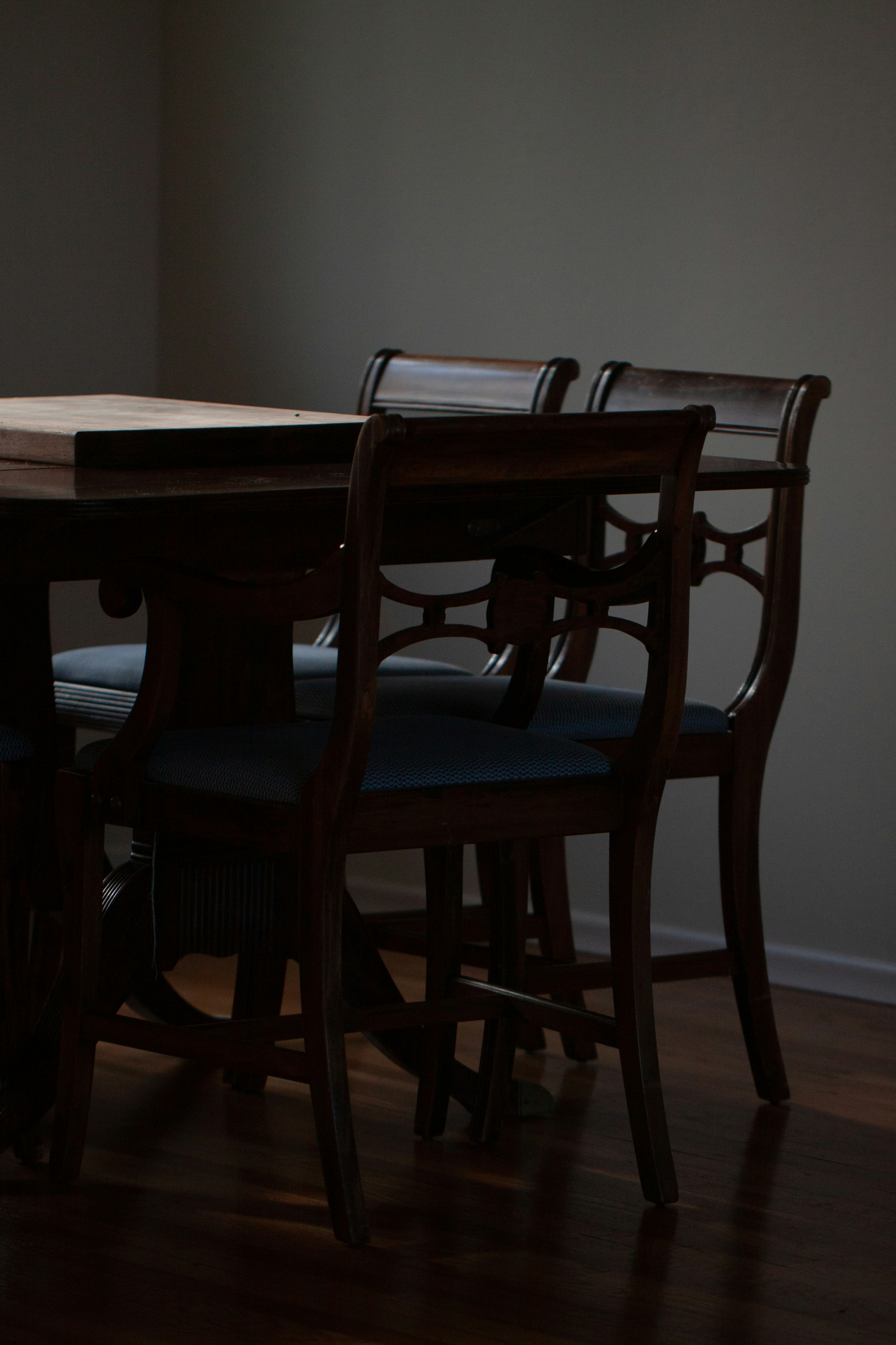 Dimly Lit Dining: A Quiet Table Surrounded by Shadowed Chairs