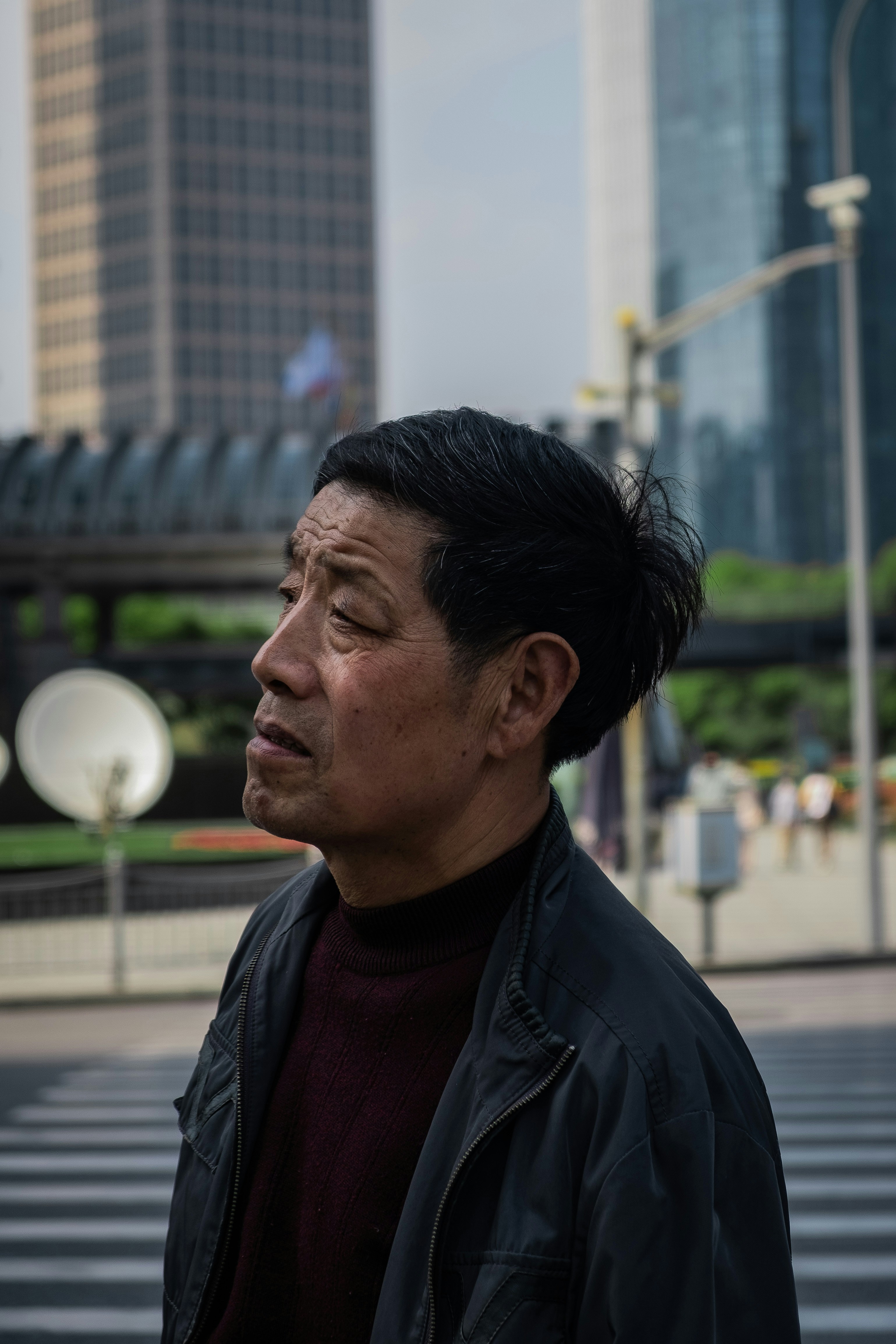 Man standing on a city street with skyscrapers in the background.