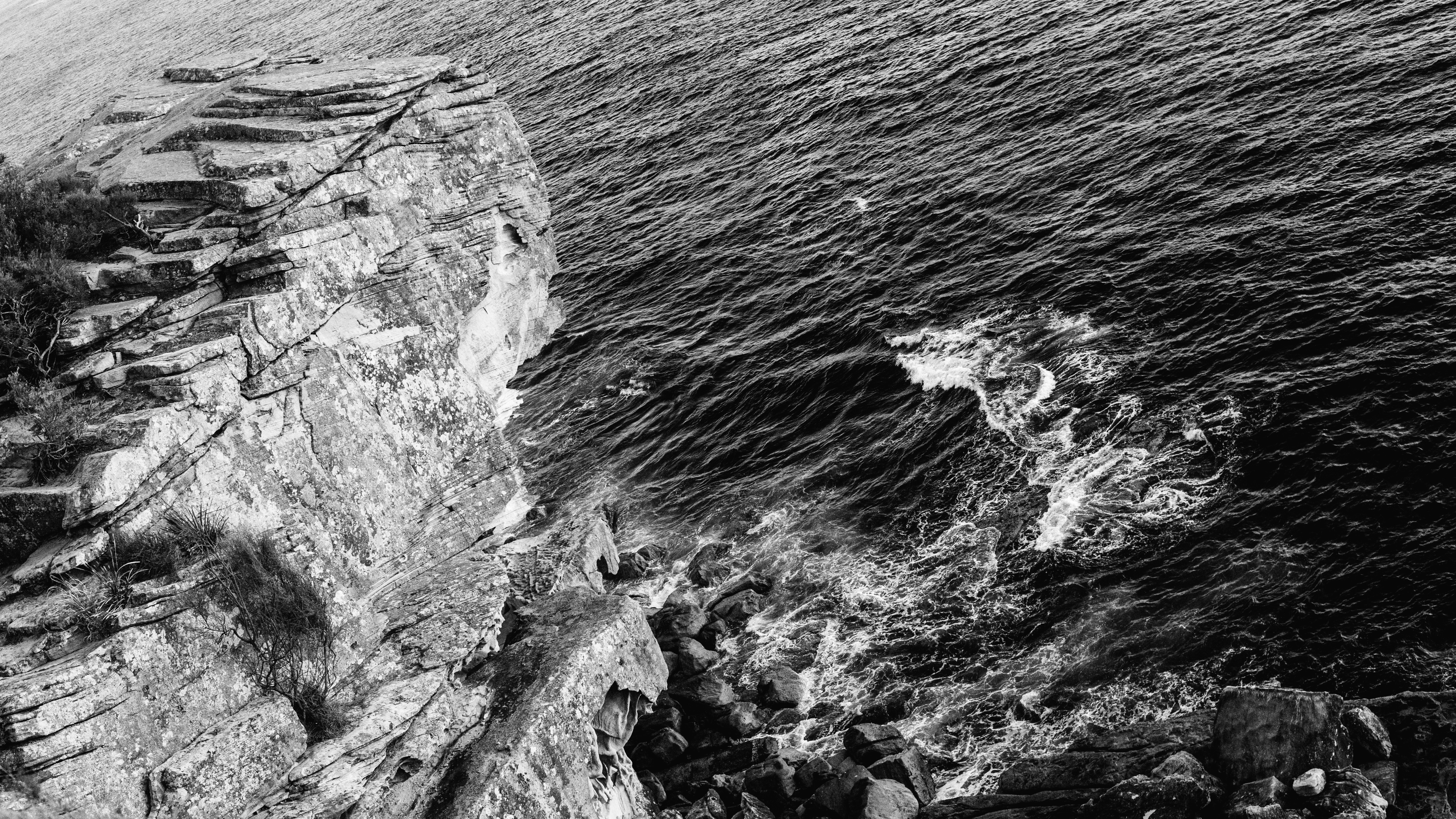 Aerial grayscale photography of waves splashing on rock walls photo ...