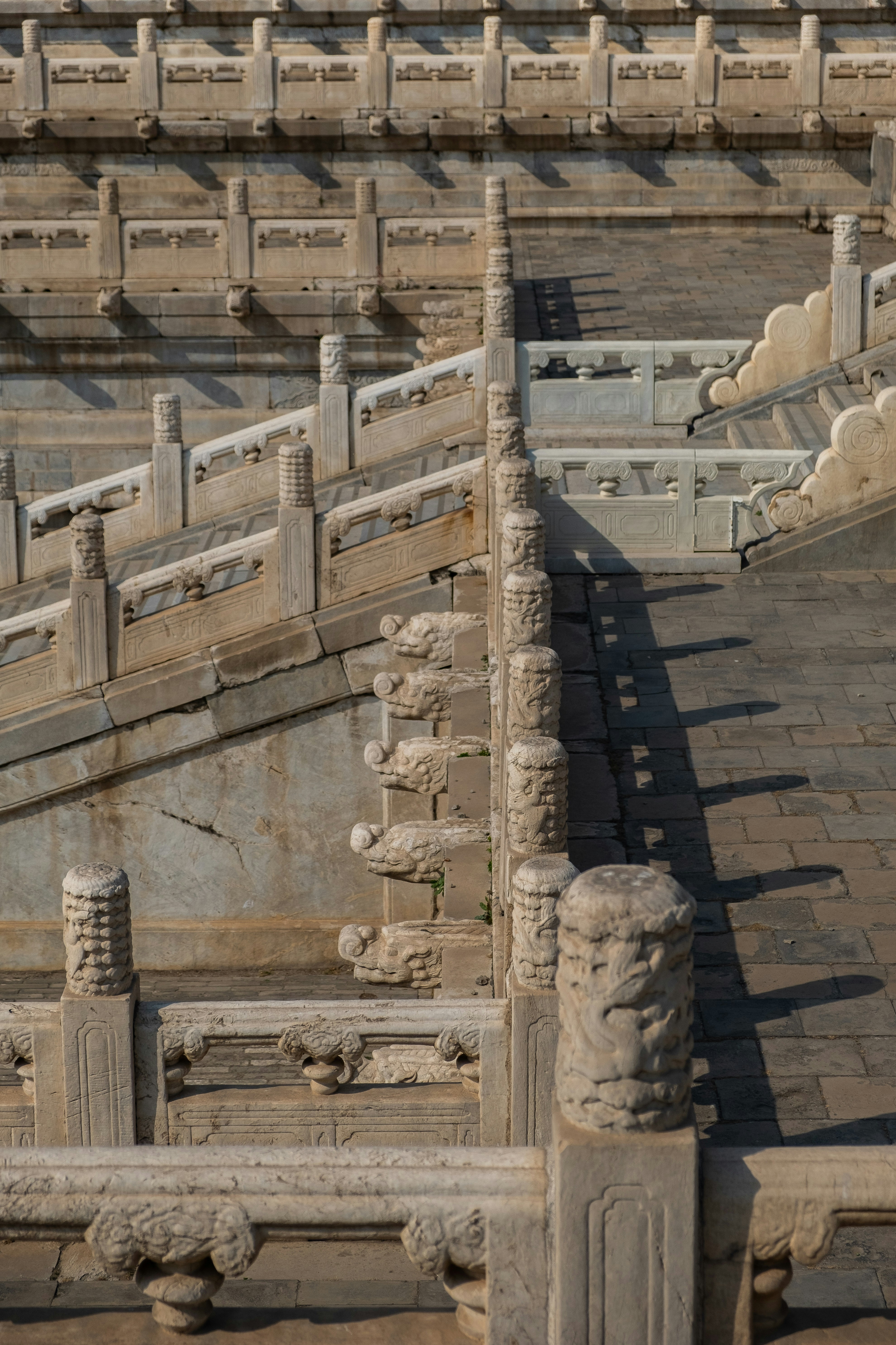 Angled stone stairs and carved balustrades in a sunlit ancient terrace