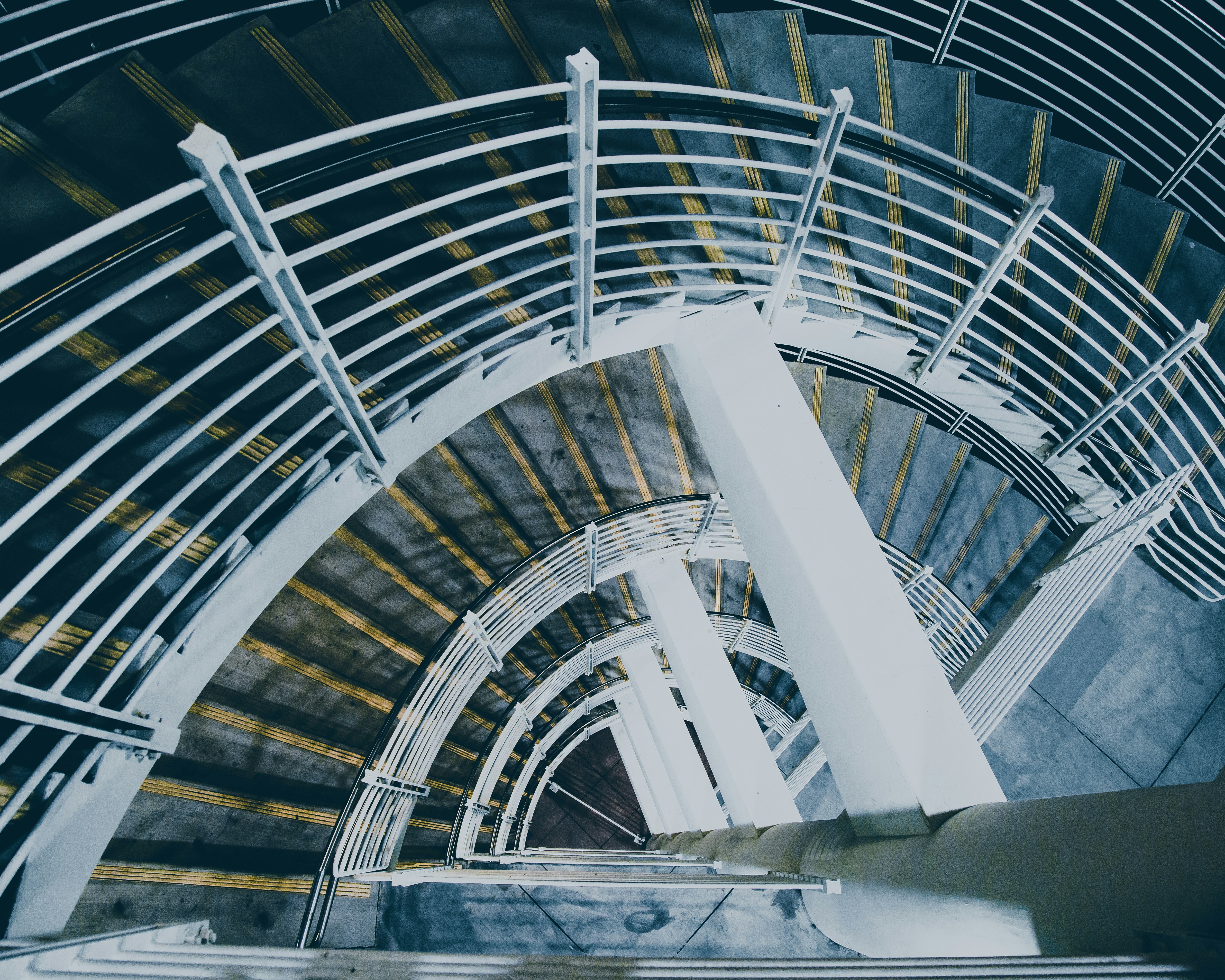 Spiral staircase with metal railings and contrasting steps in a modern building.