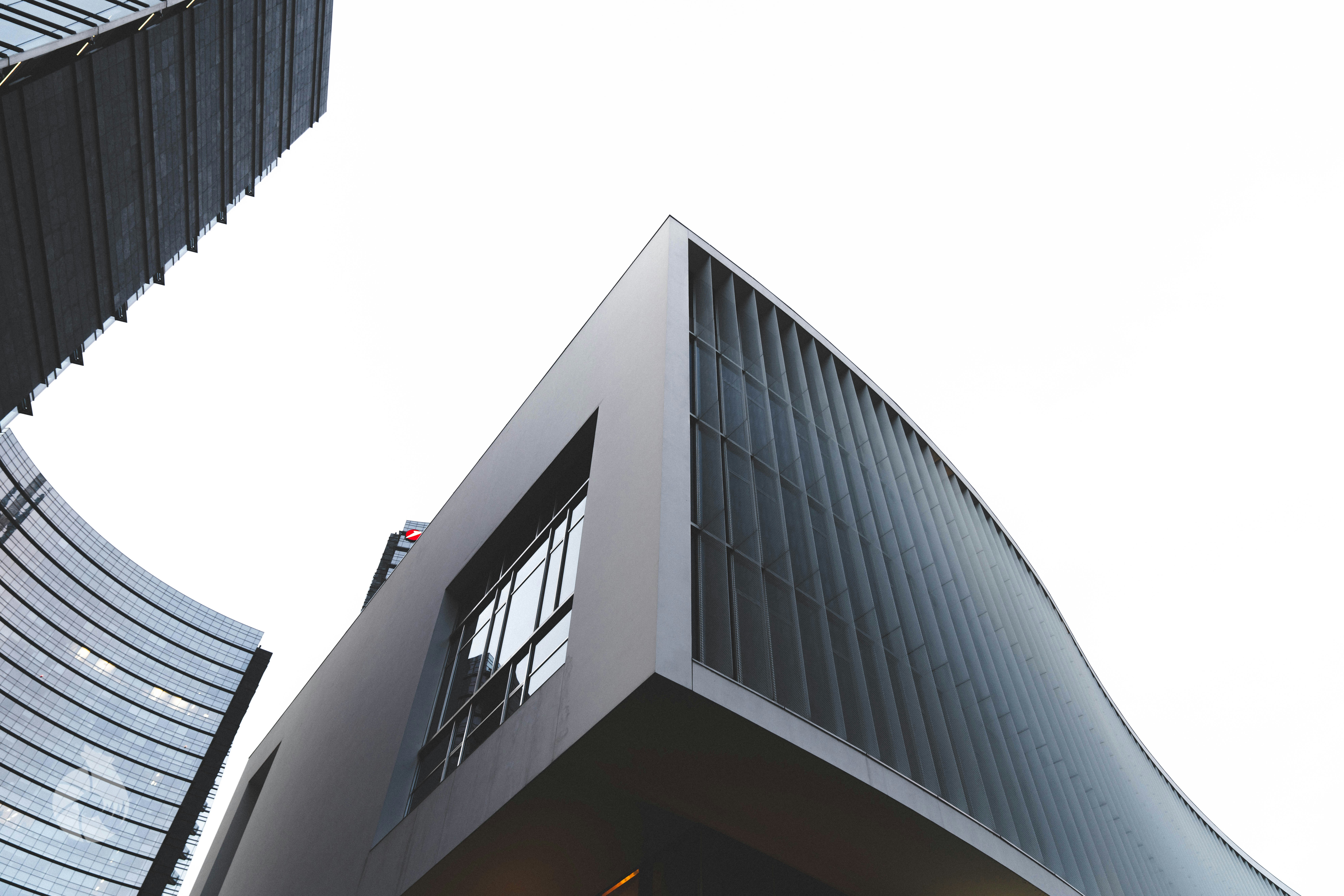 Angular modern building framed by sleek glass structures, showcasing innovative design elements and urban aesthetics.