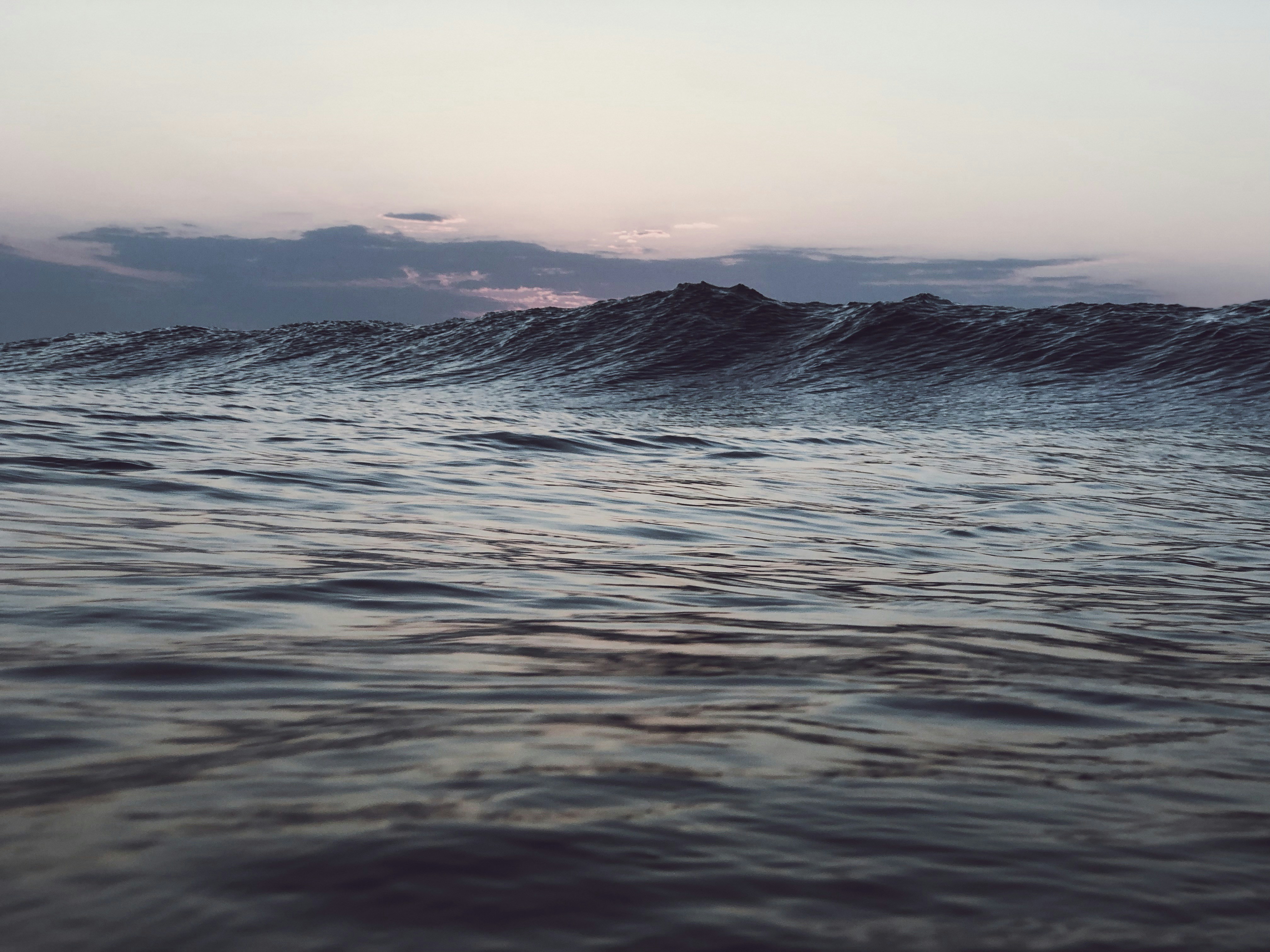Dusk Crest Over a Quiet Sea: Waves Beneath a Pastel Horizon