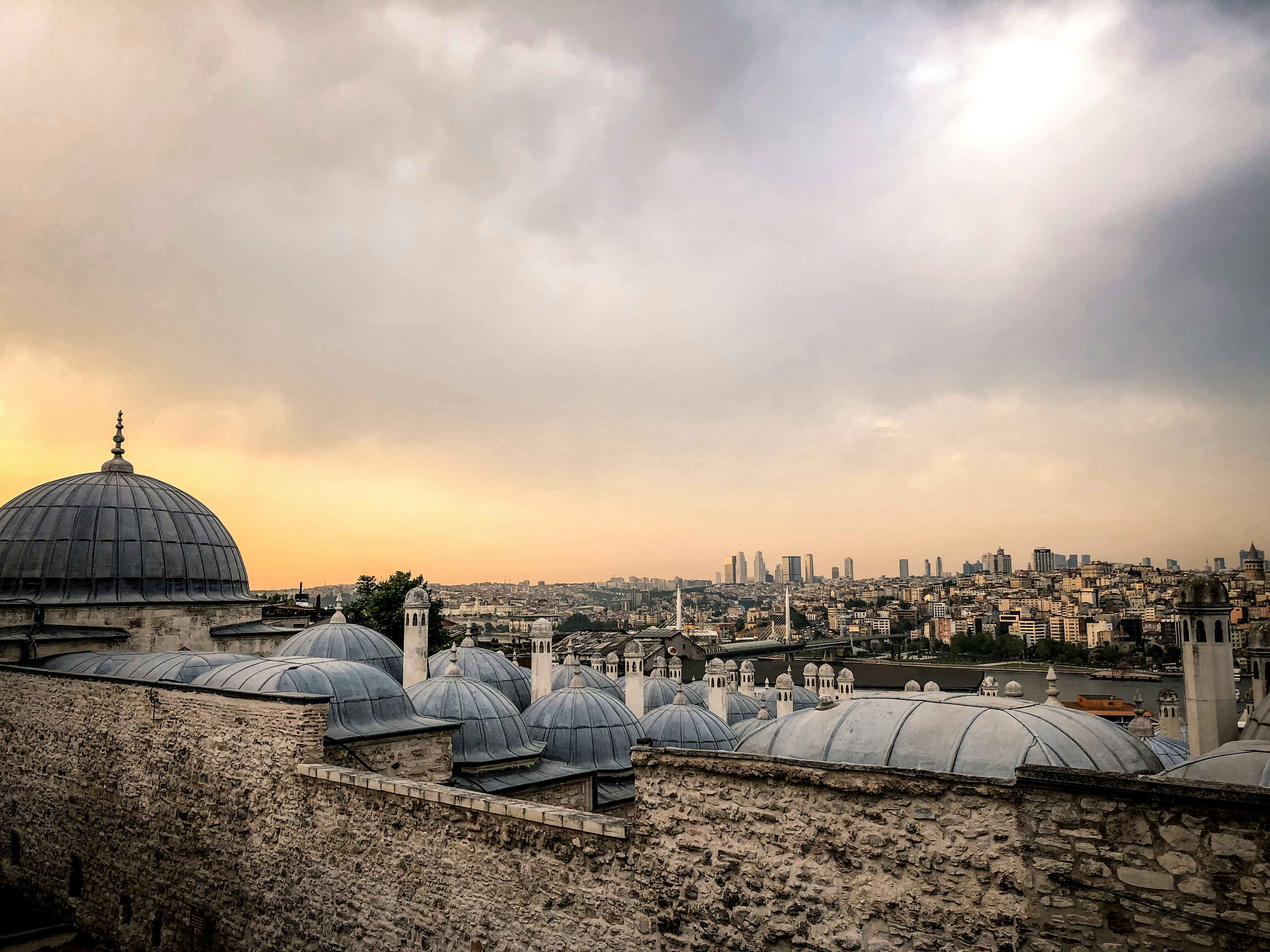 Dome Row at Dusk: Rooftop Stonework Framing a Faraway Skyline