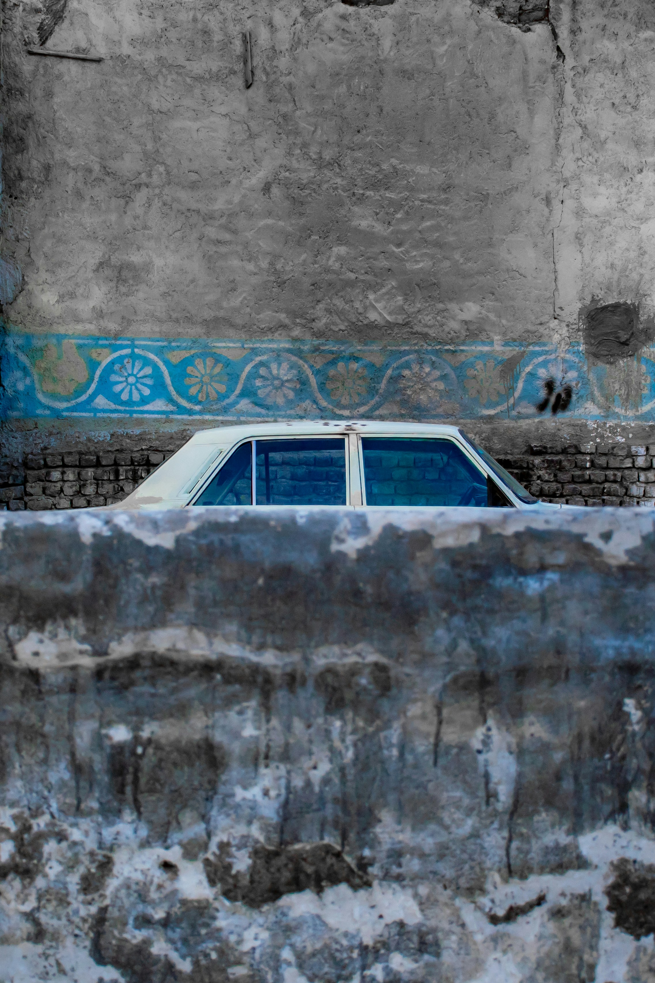 Vintage Sedan Peeks Over a Weathered Wall