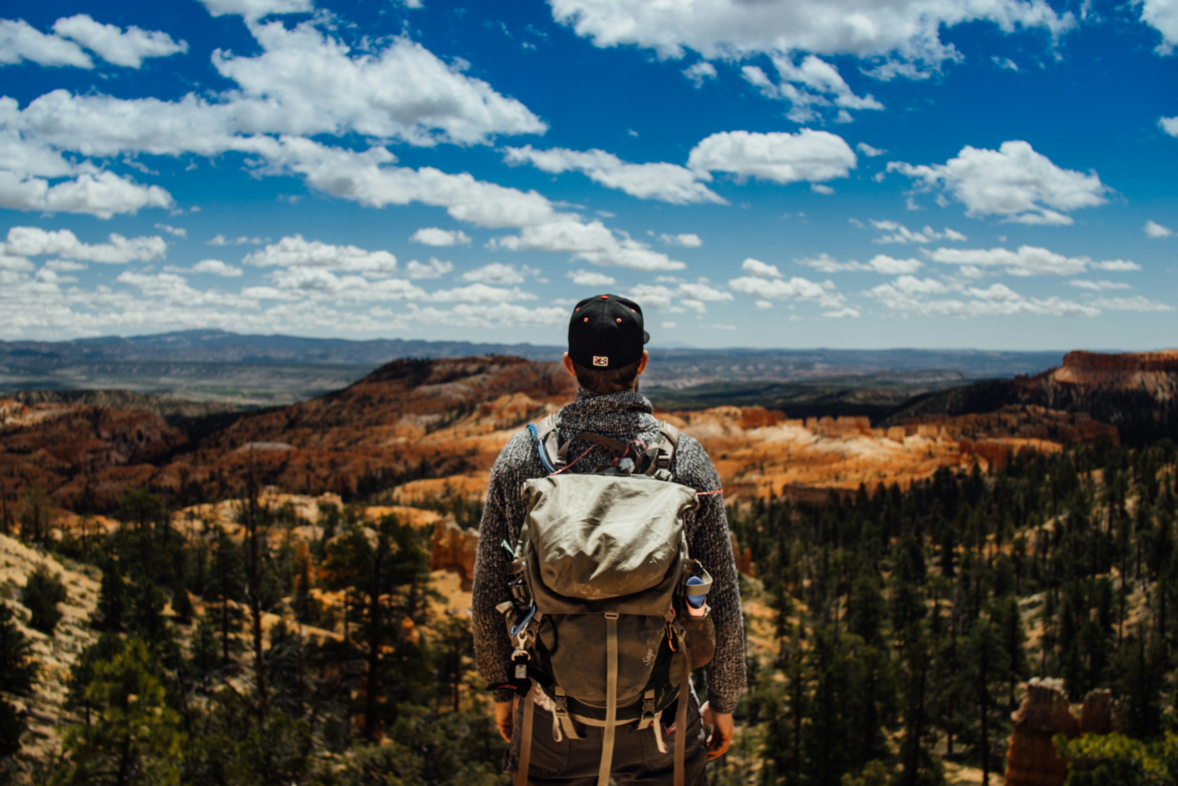 Man in cap and backpack standing on top of mountain photo – Free Tree ...
