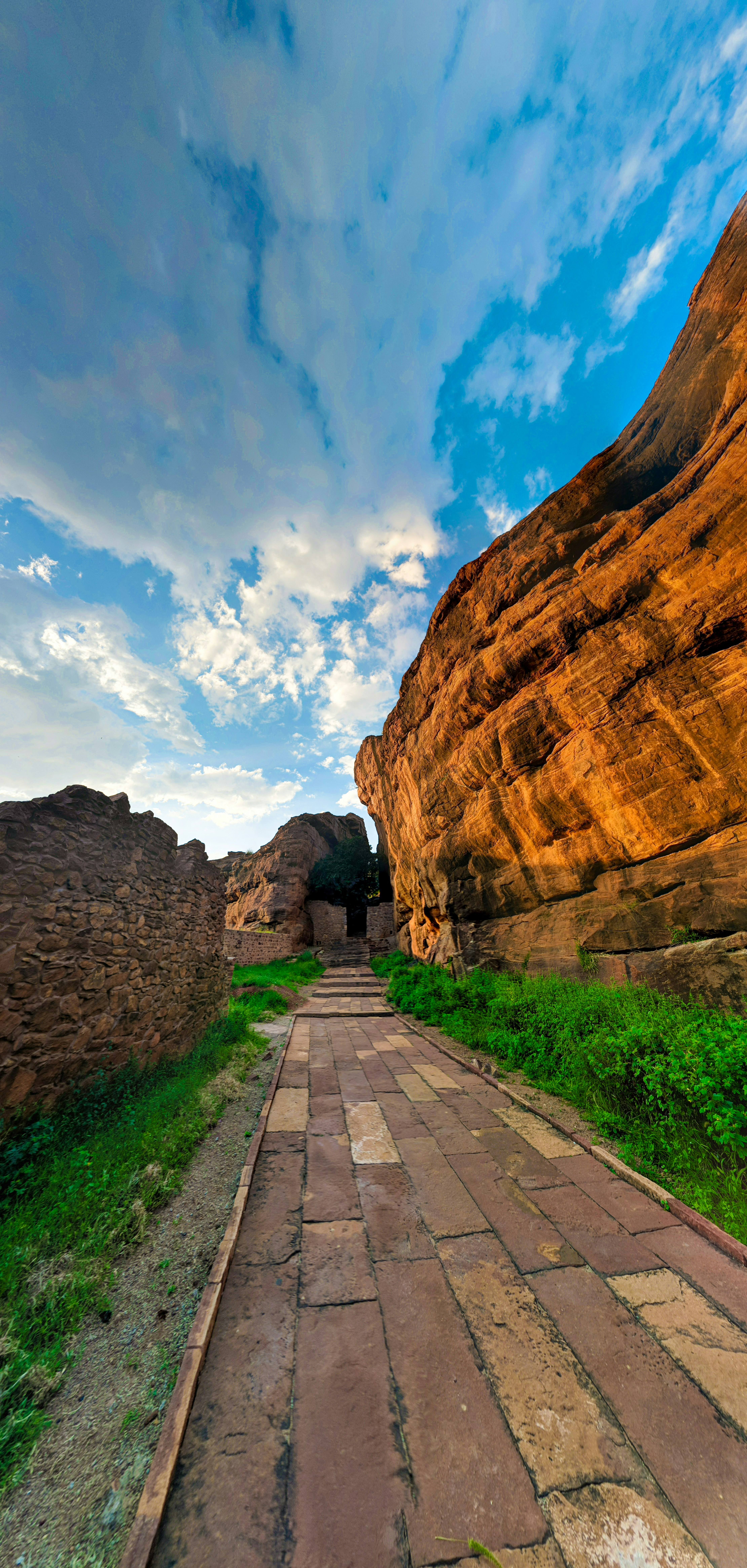 Sunlit Corridor: A Path Through Ancient Ruins Beneath a Wide Sky