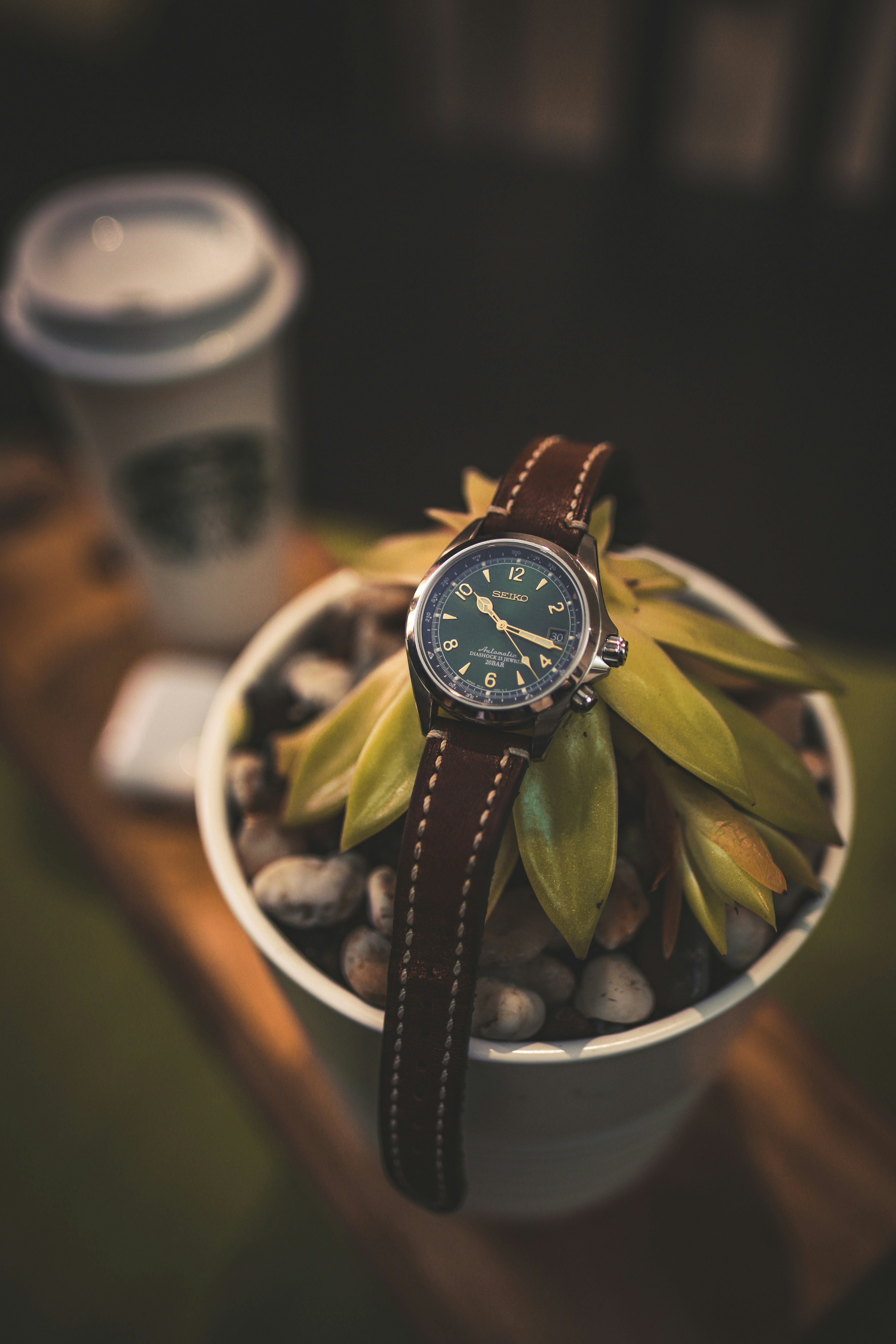 round silver-colored analog watch with brown leather strap