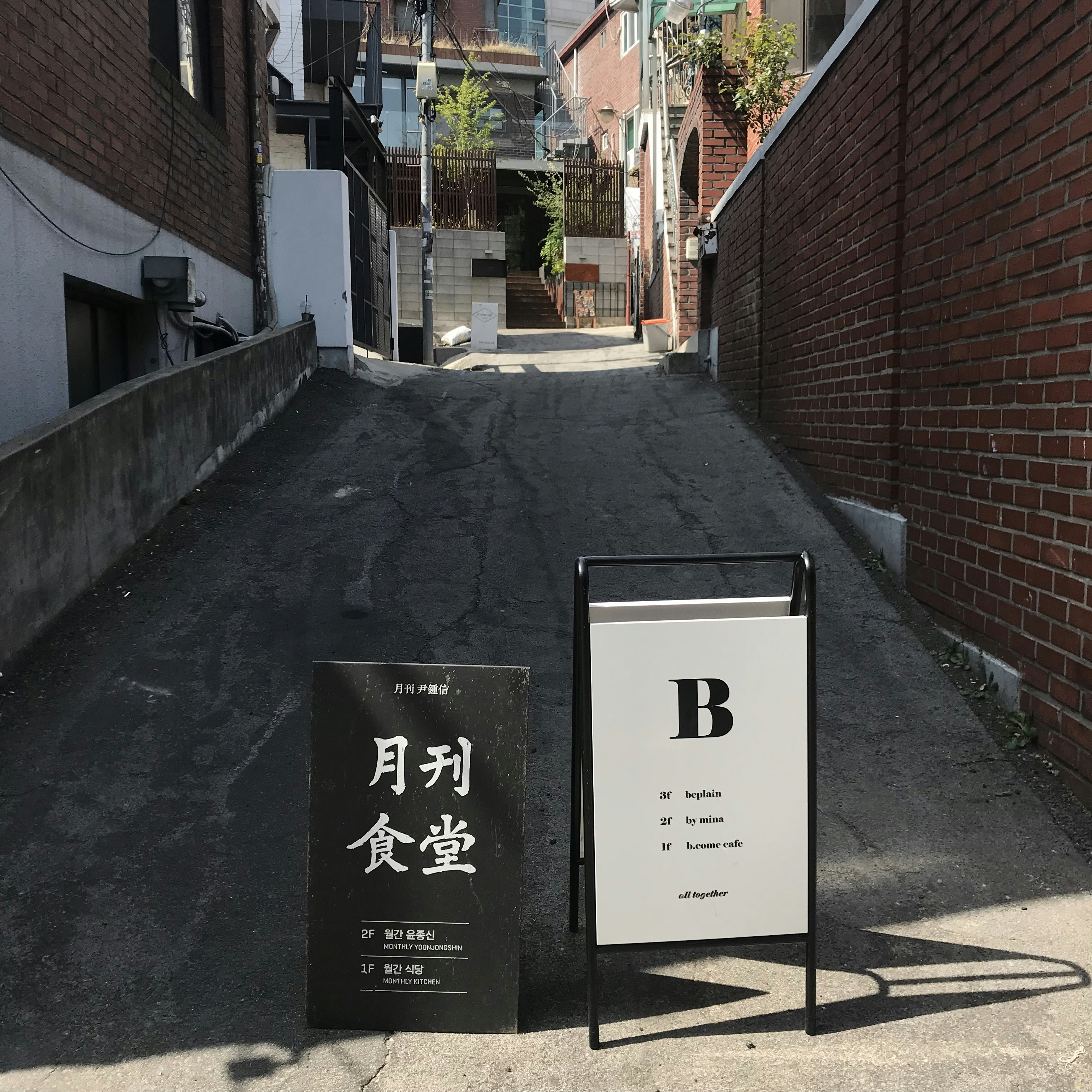 Black and white road signs between buildings photo – Free Grey Image on ...