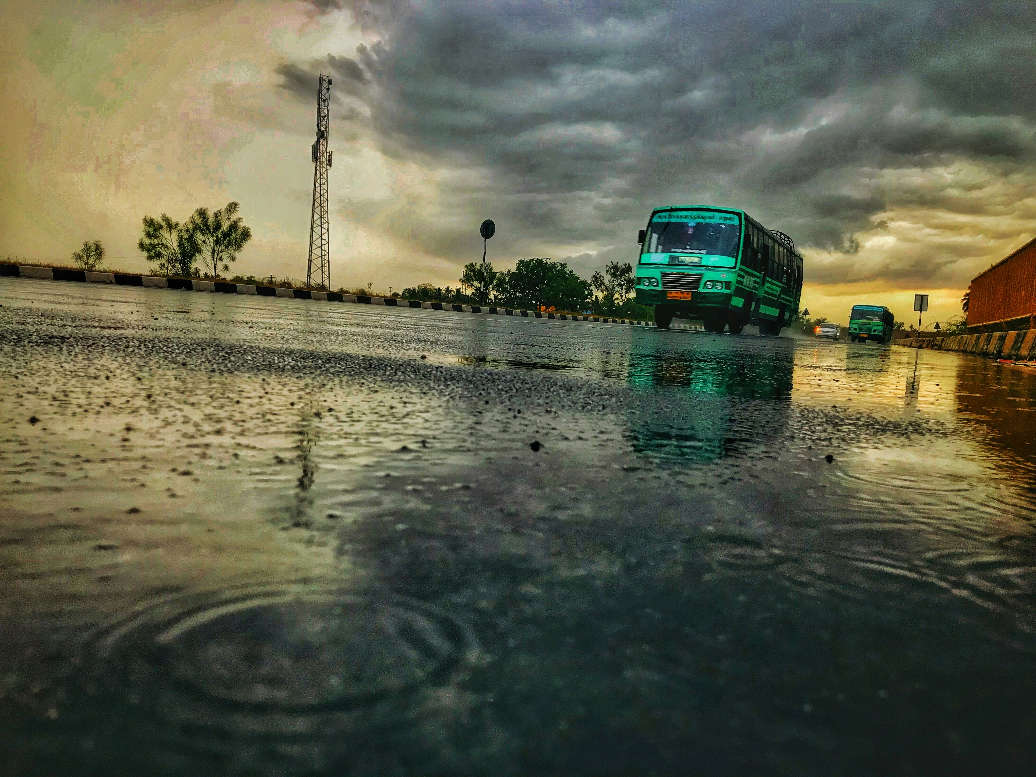 Puddled Roadway UnderStorm: A Bus and Twilight Sky