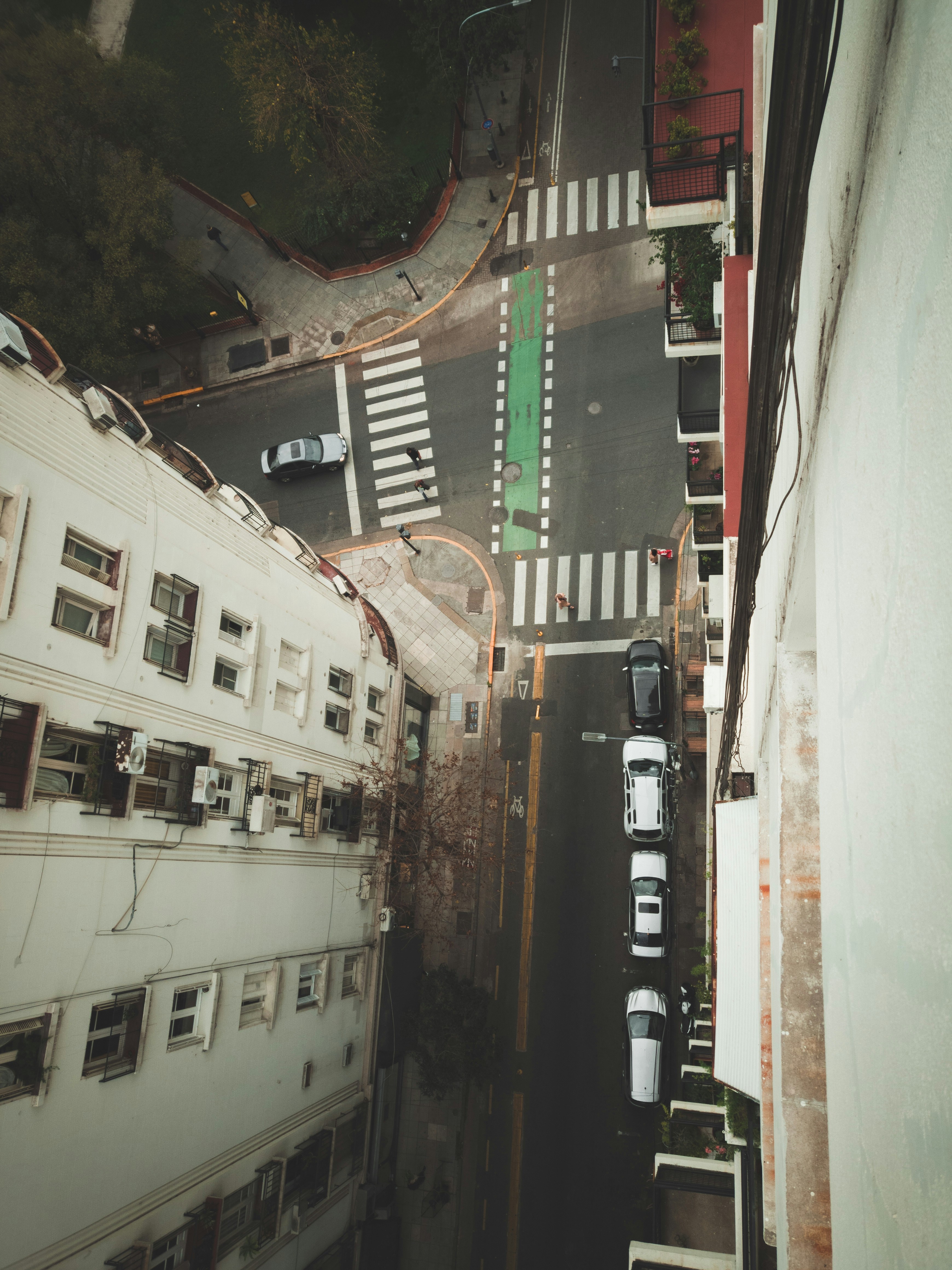 Aerial view of vehicles parked on sidewalk between buildings photo ...