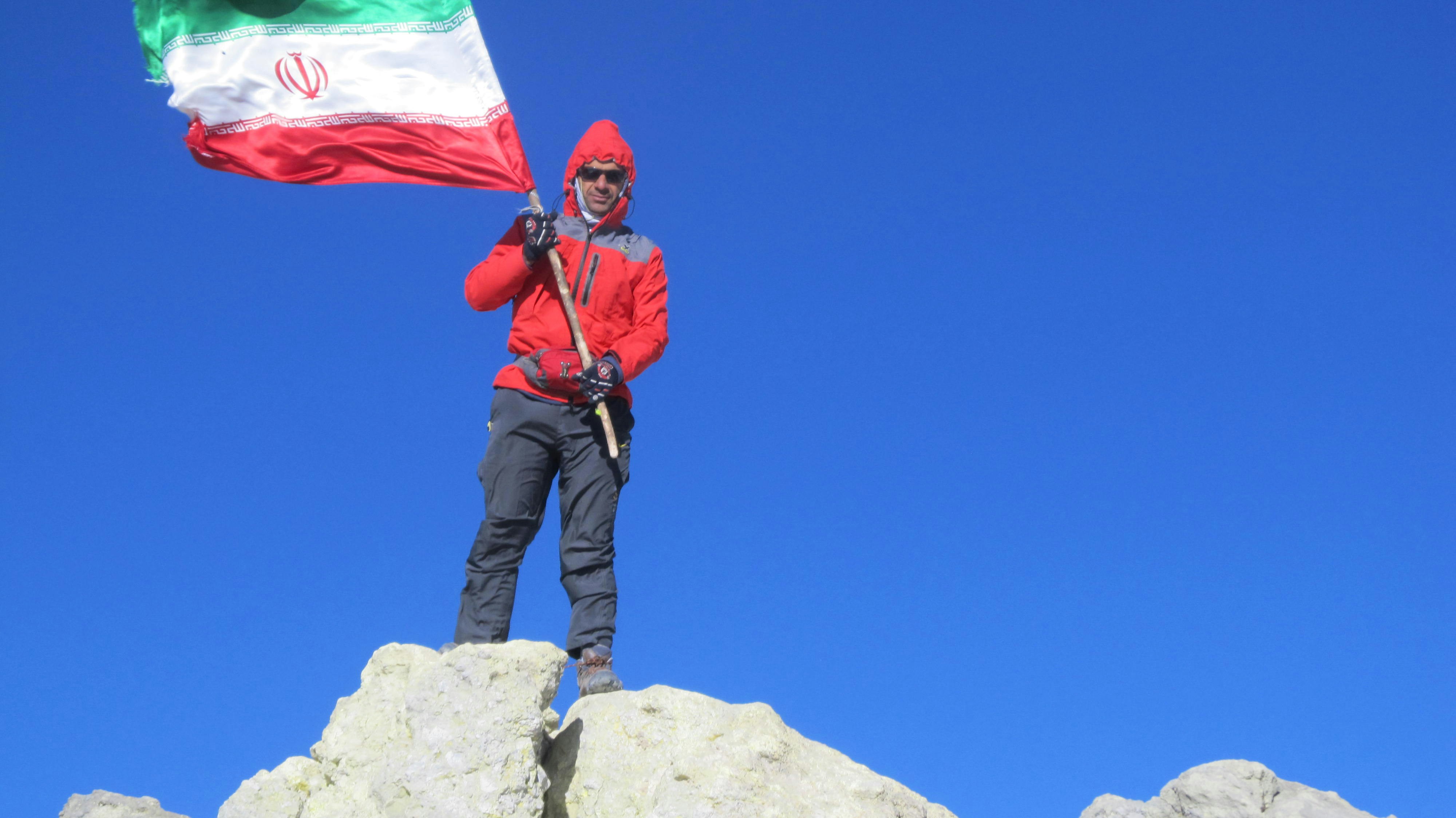 Flagbearer on a Granite Crest under a Pristine Blue Sky