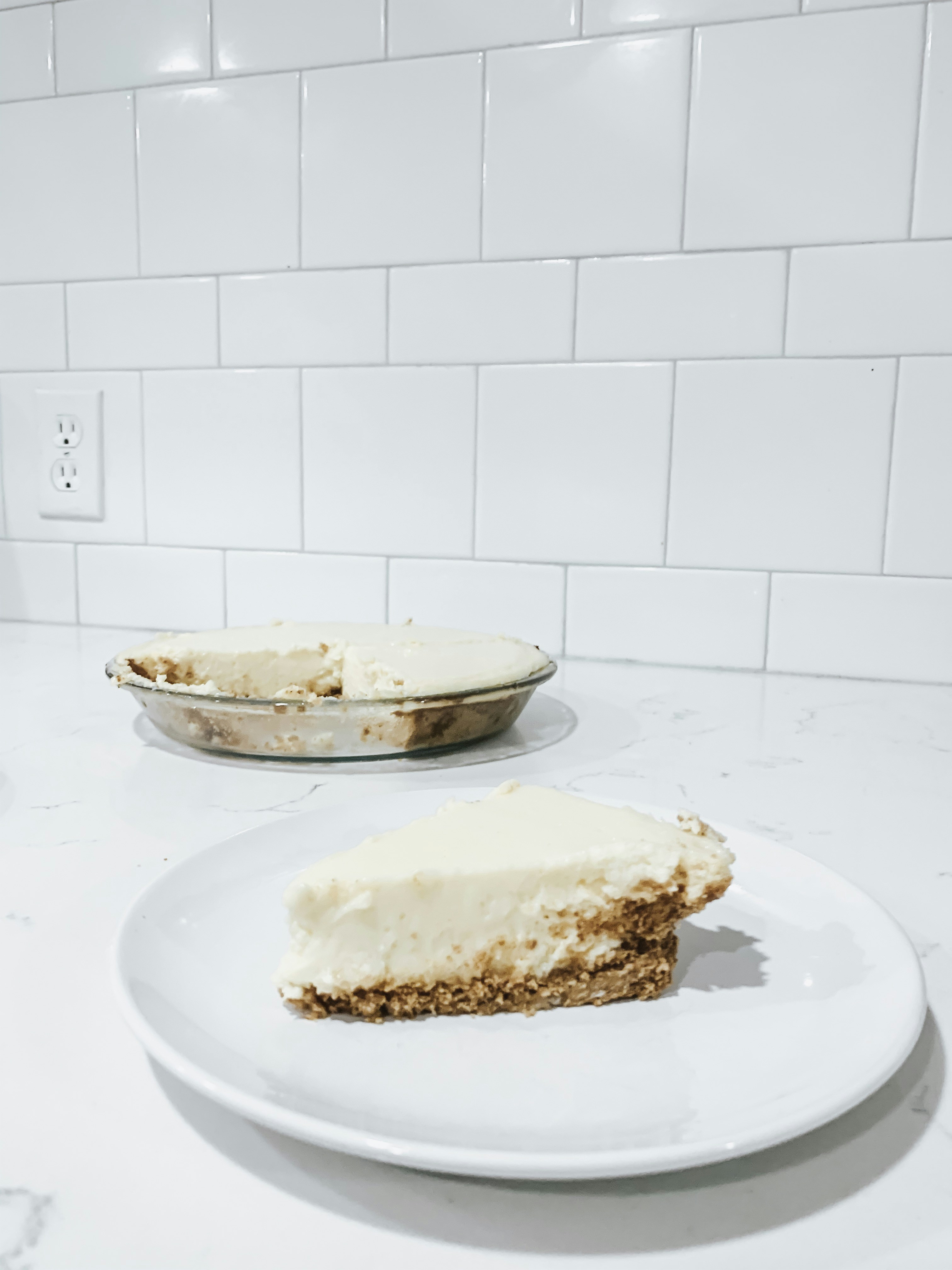 Creamy Cheesecake Slice on Marble Counter in a Bright White Kitchen