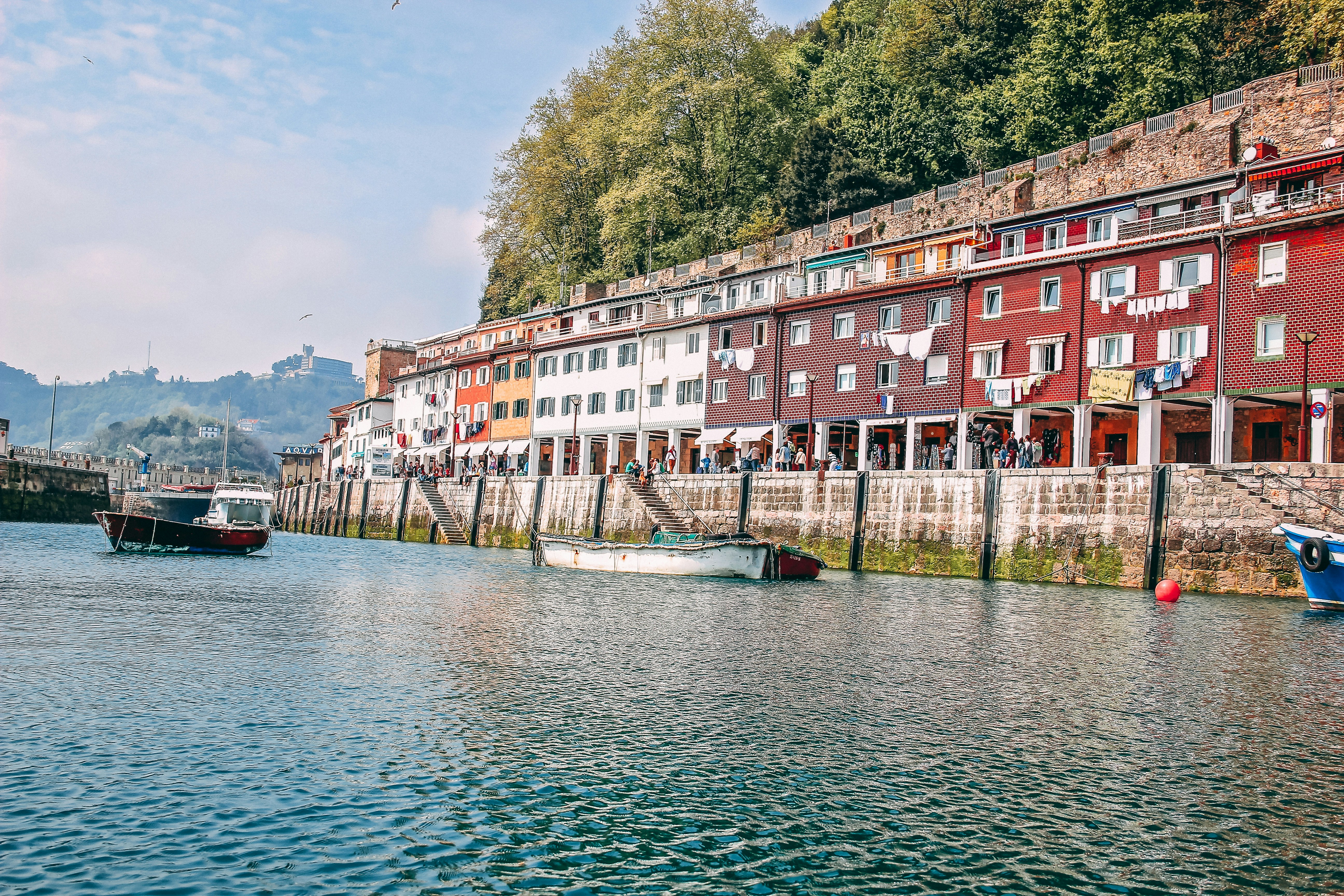 Riverfront Rows: Boats, Buildings, and Blue Reflections
