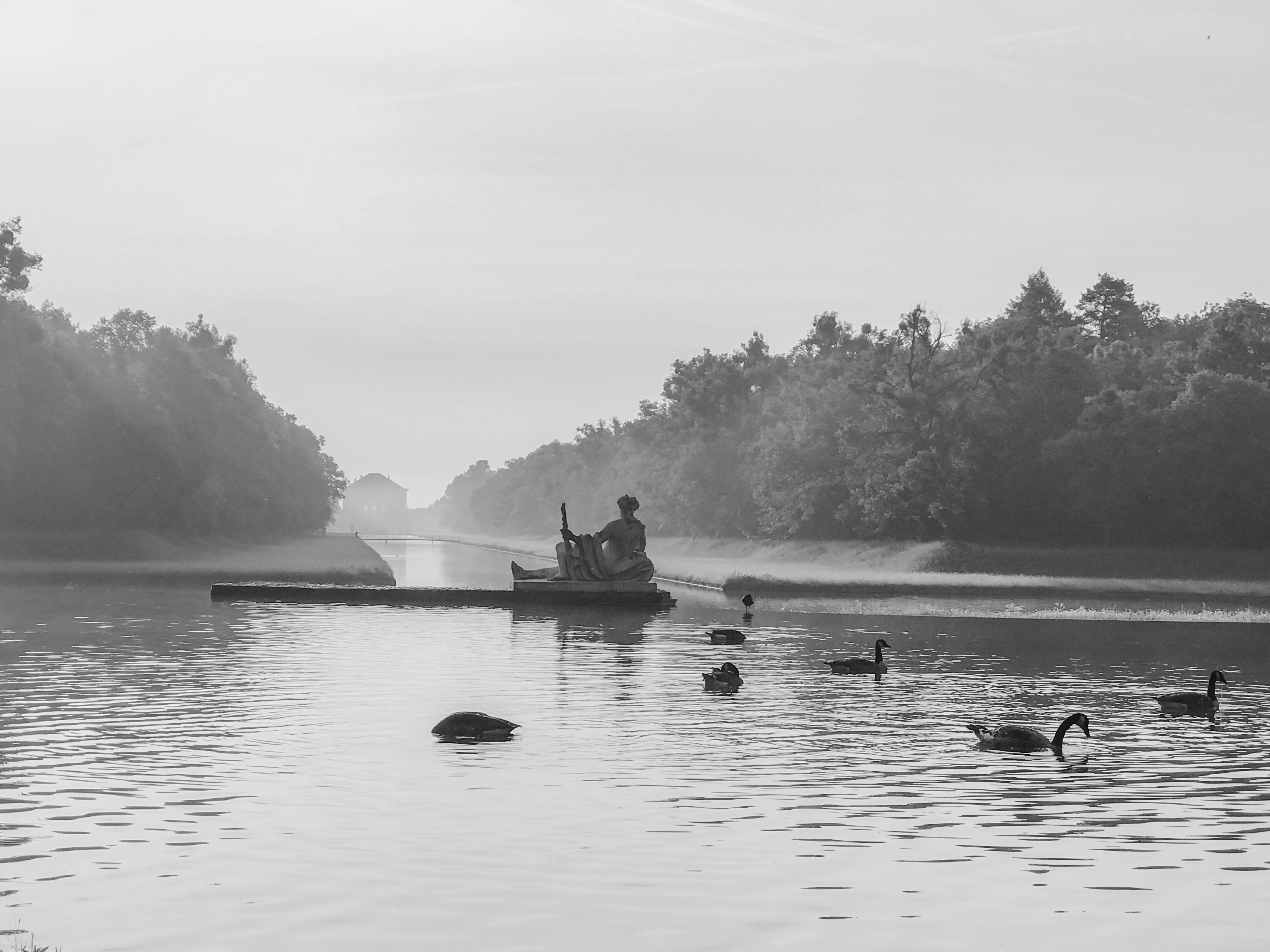 Quiet River Crossing: A Silhouetted Canoe Beneath Distant Trees