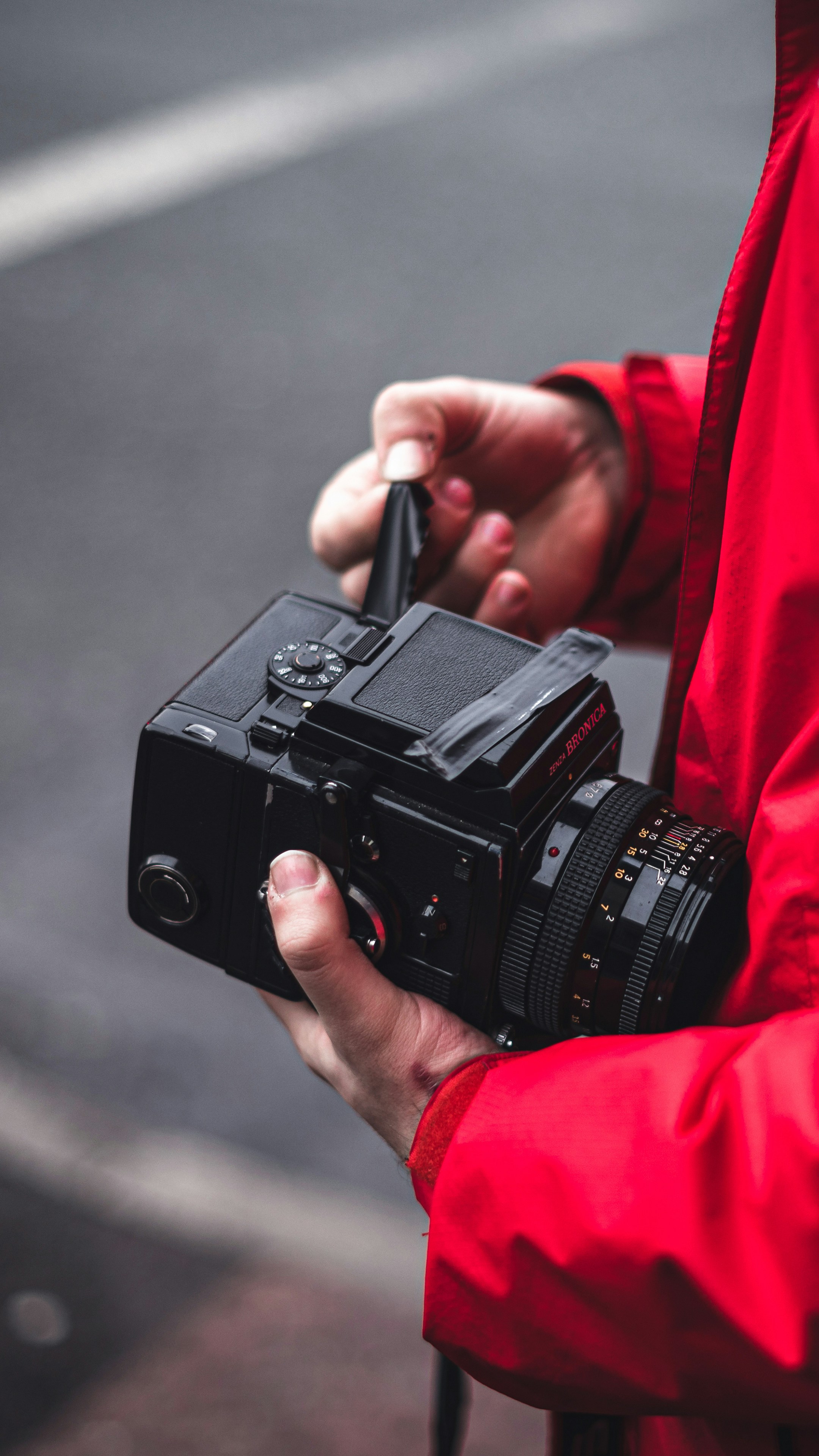 Crimson Grip: A Street Moment with a Classic-Style Camera