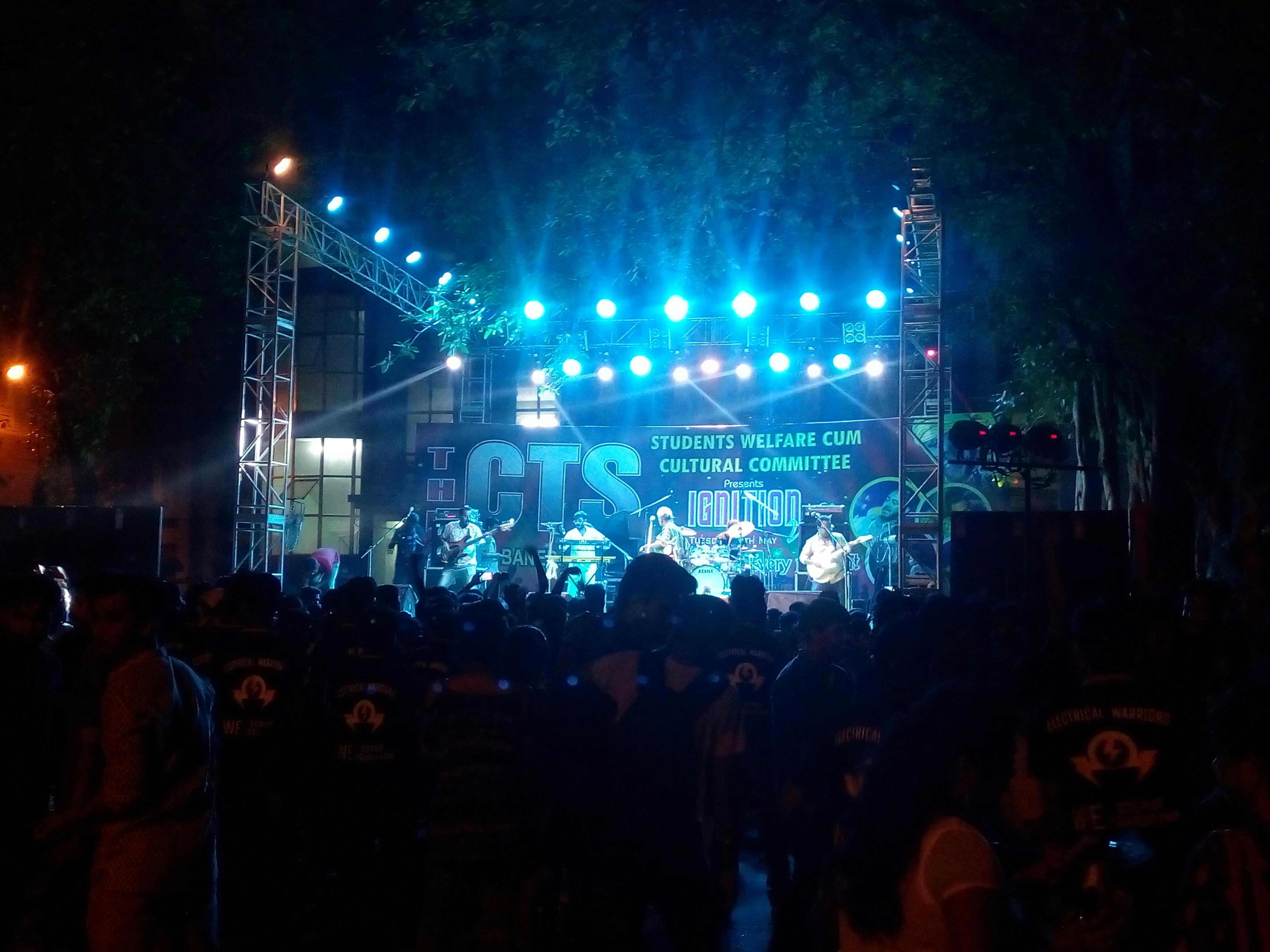 Neon Blues Over a Crowded Campus Stage