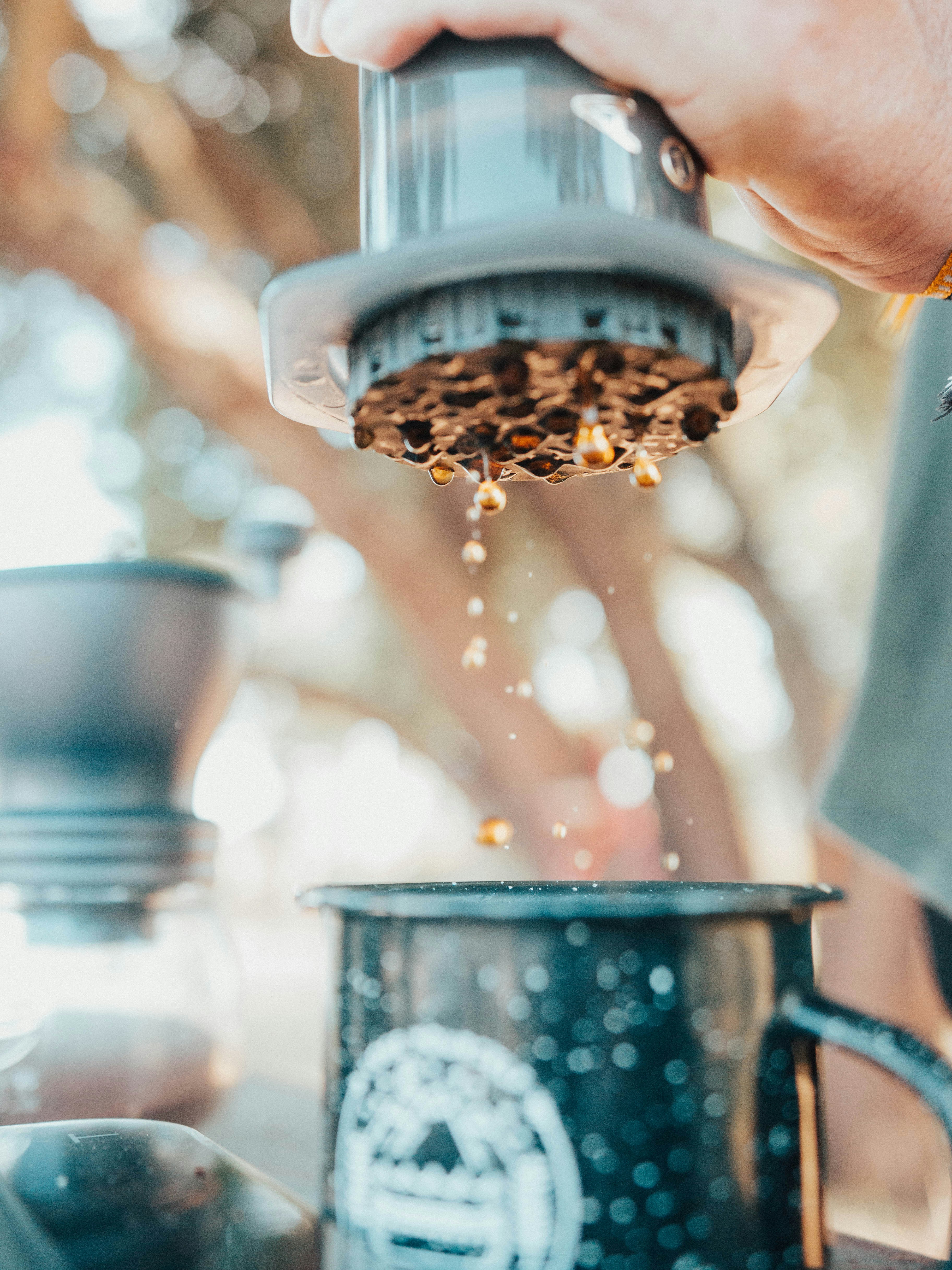 Coffee grounds cascading from a manual grinder into a waiting mug, capturing the essence of the brewing process.