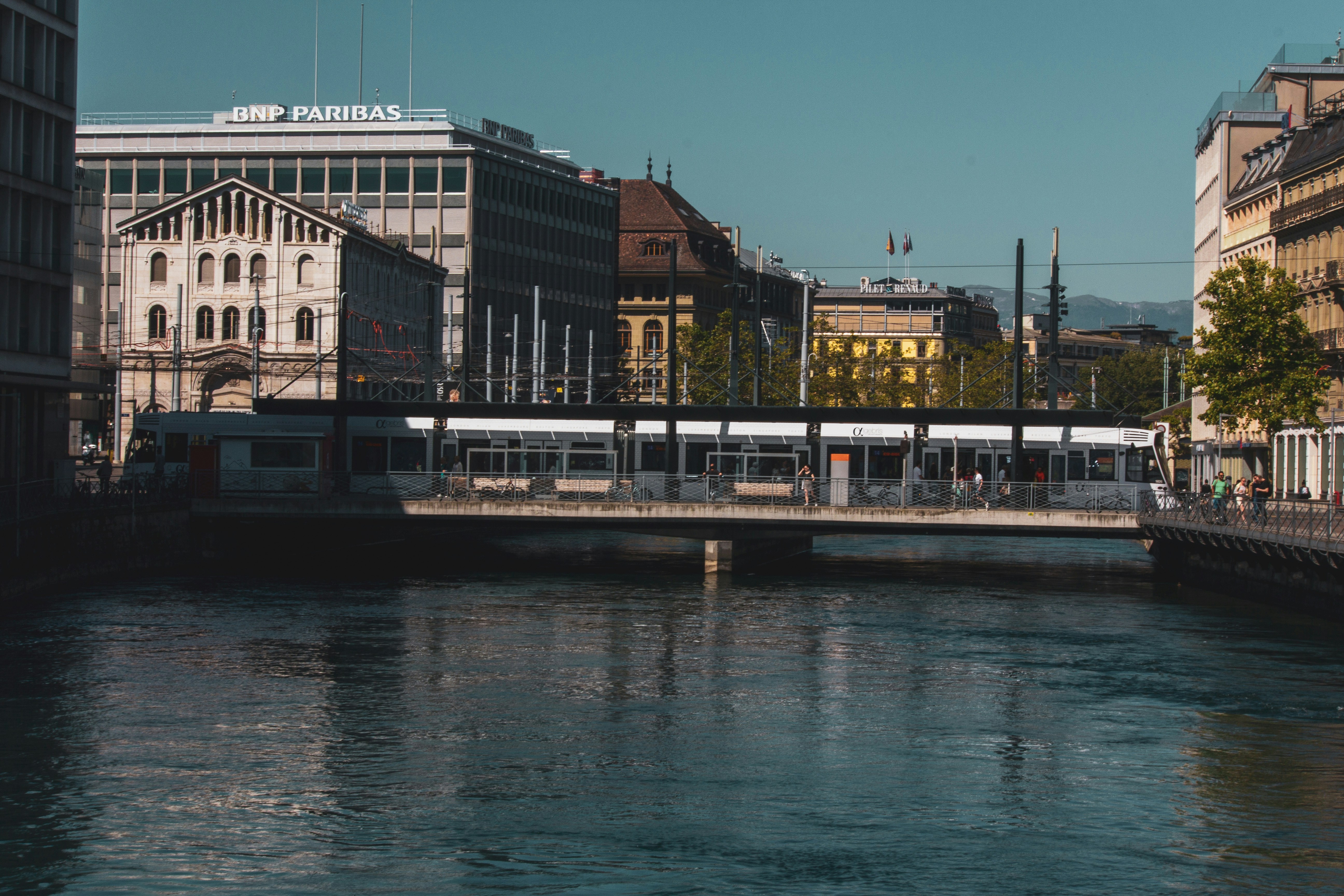 Foto Puente de hormigón gris rodeado de edificios – Imagen Agua gratis en Unsplash