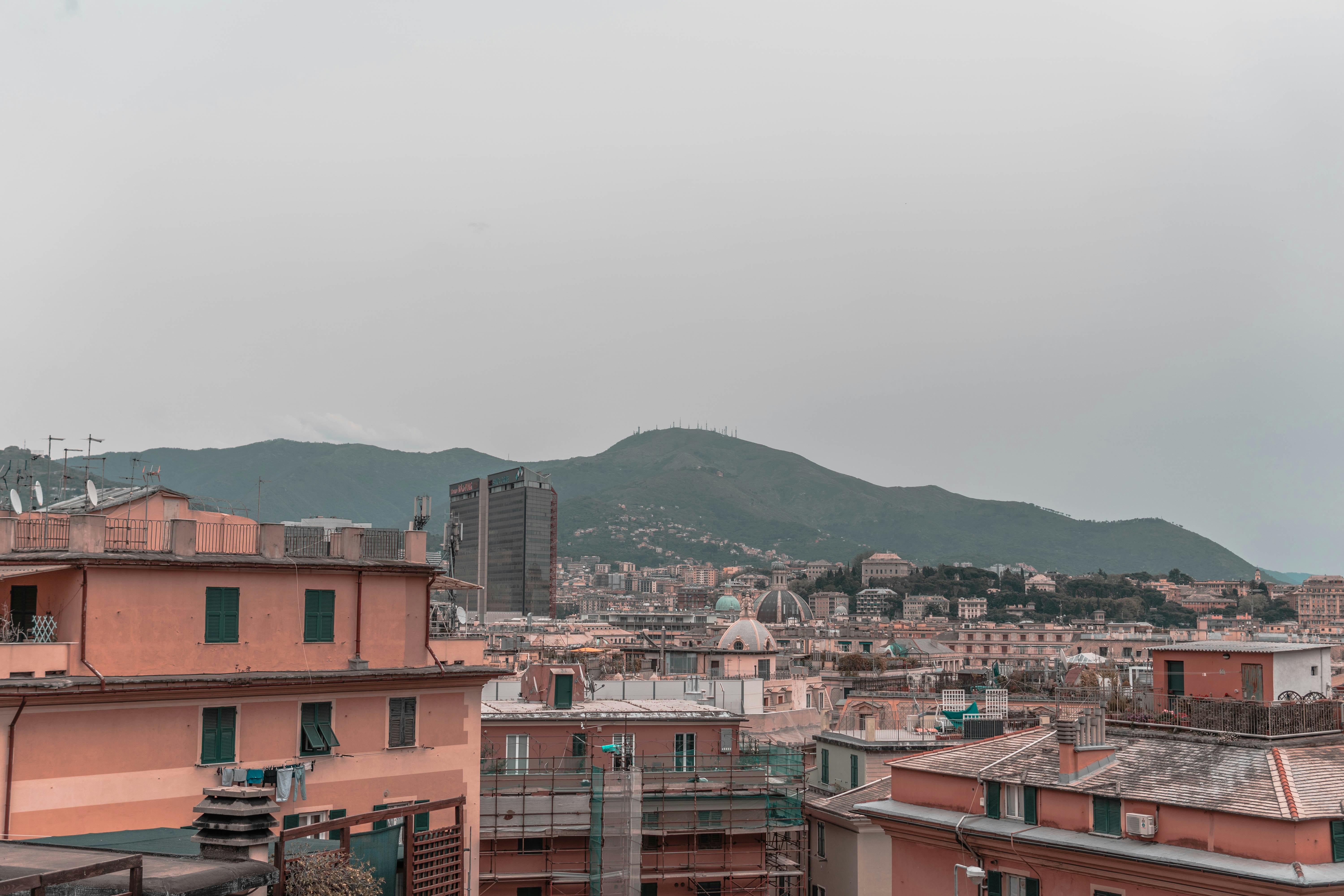 Muted rooftops and distant hills under an overcast sky.