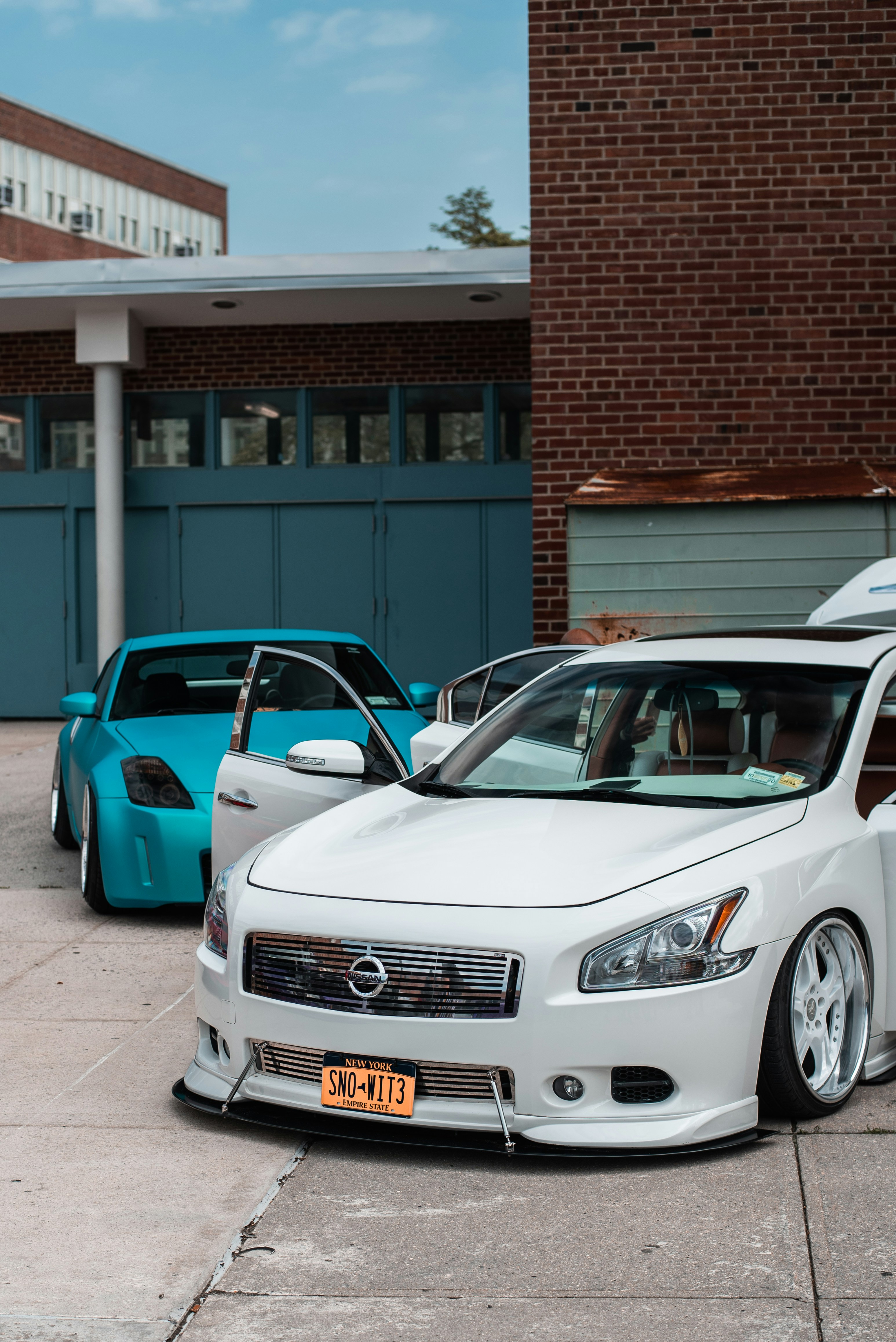 Coche Nissan blanco además de coche azul foto – Imagen de Automóvil ...