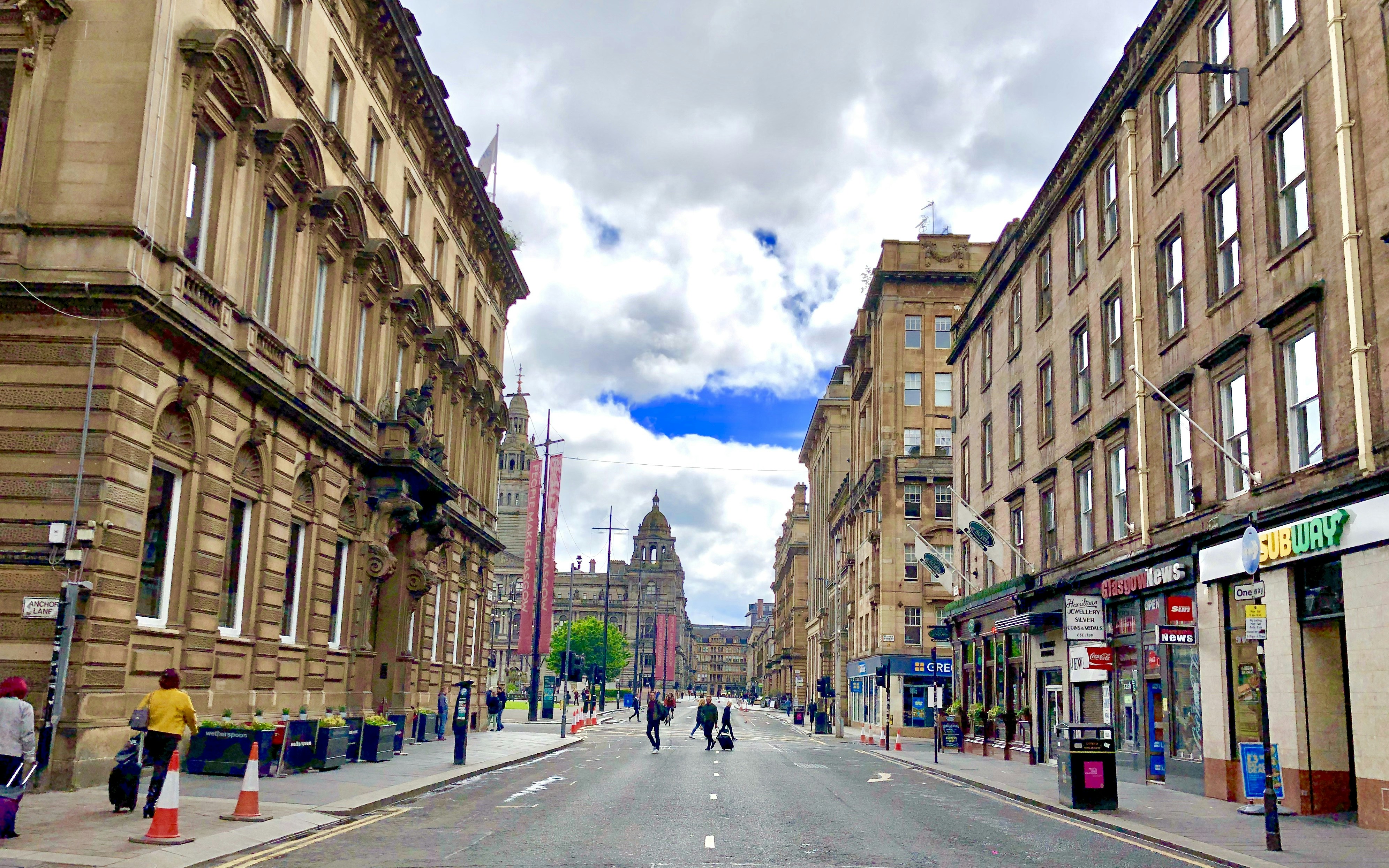 People walking on empty road between buildings photo – Free Blue Image ...