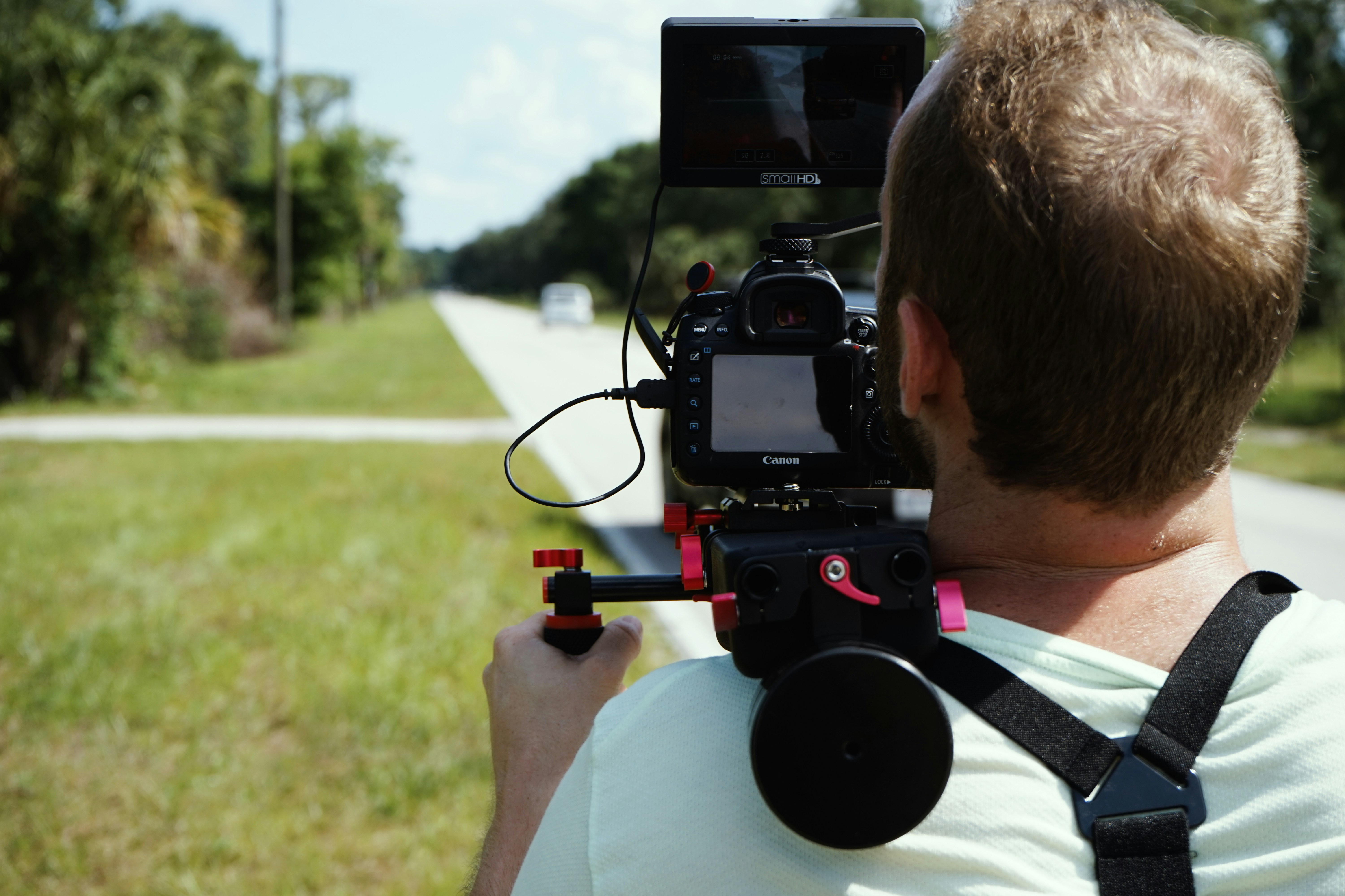 Man in white shirt carrying camera with stabilizer photo – Free Camera ...