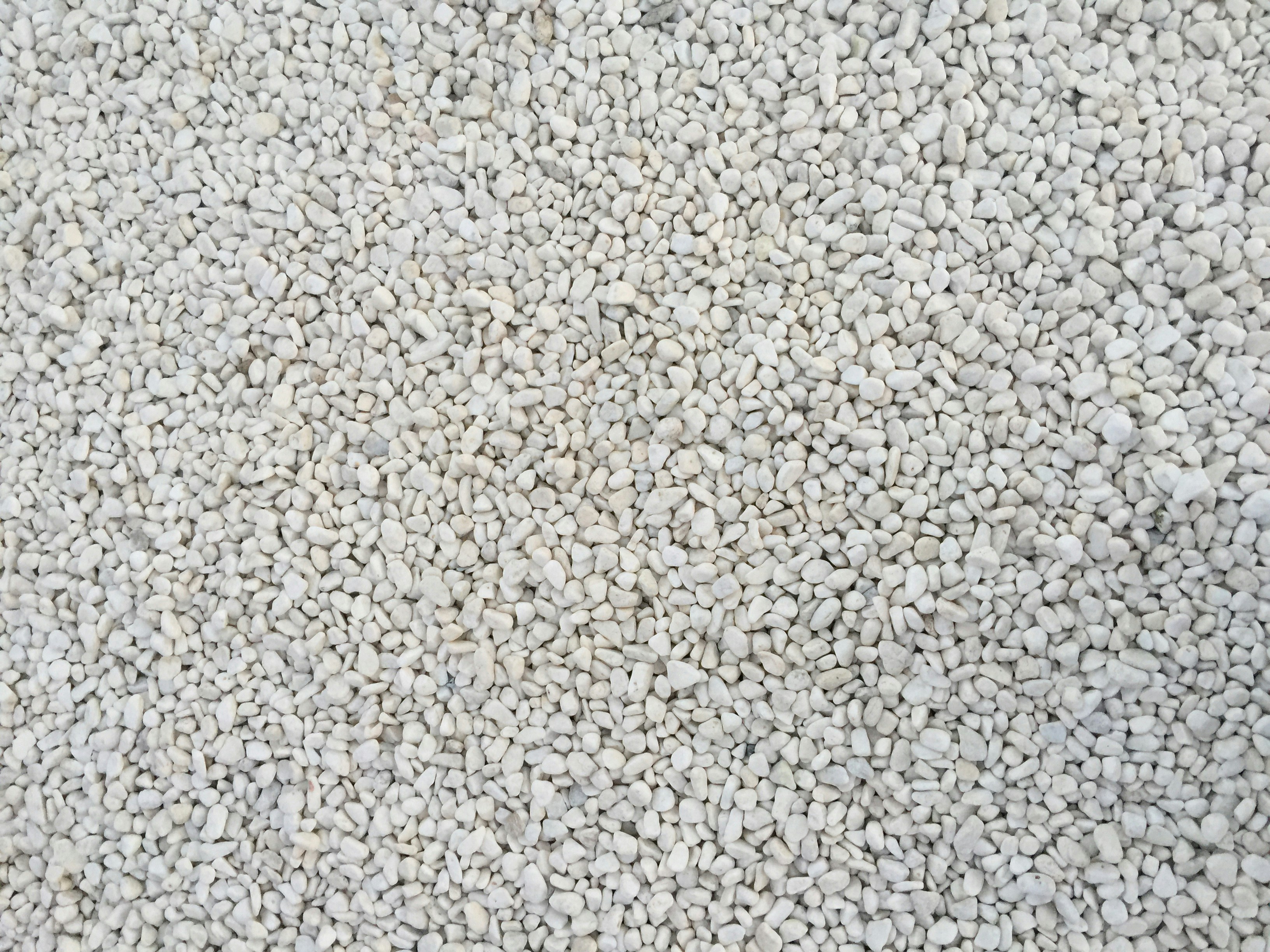 Pebbles | a close up of a white carpet with small rocks