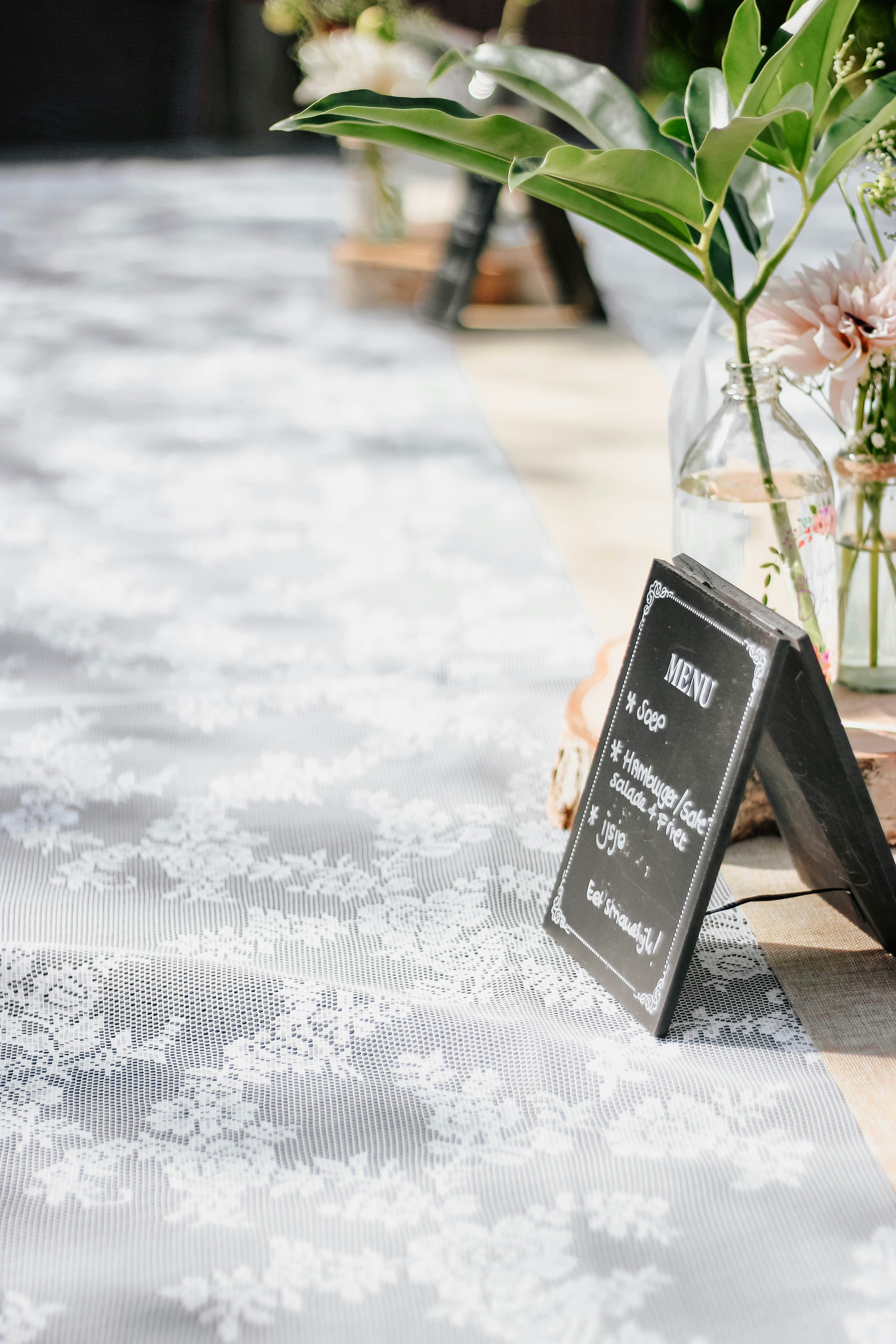 Chalkboard Menu on a Lace Tablecloth at a Sunlit Event