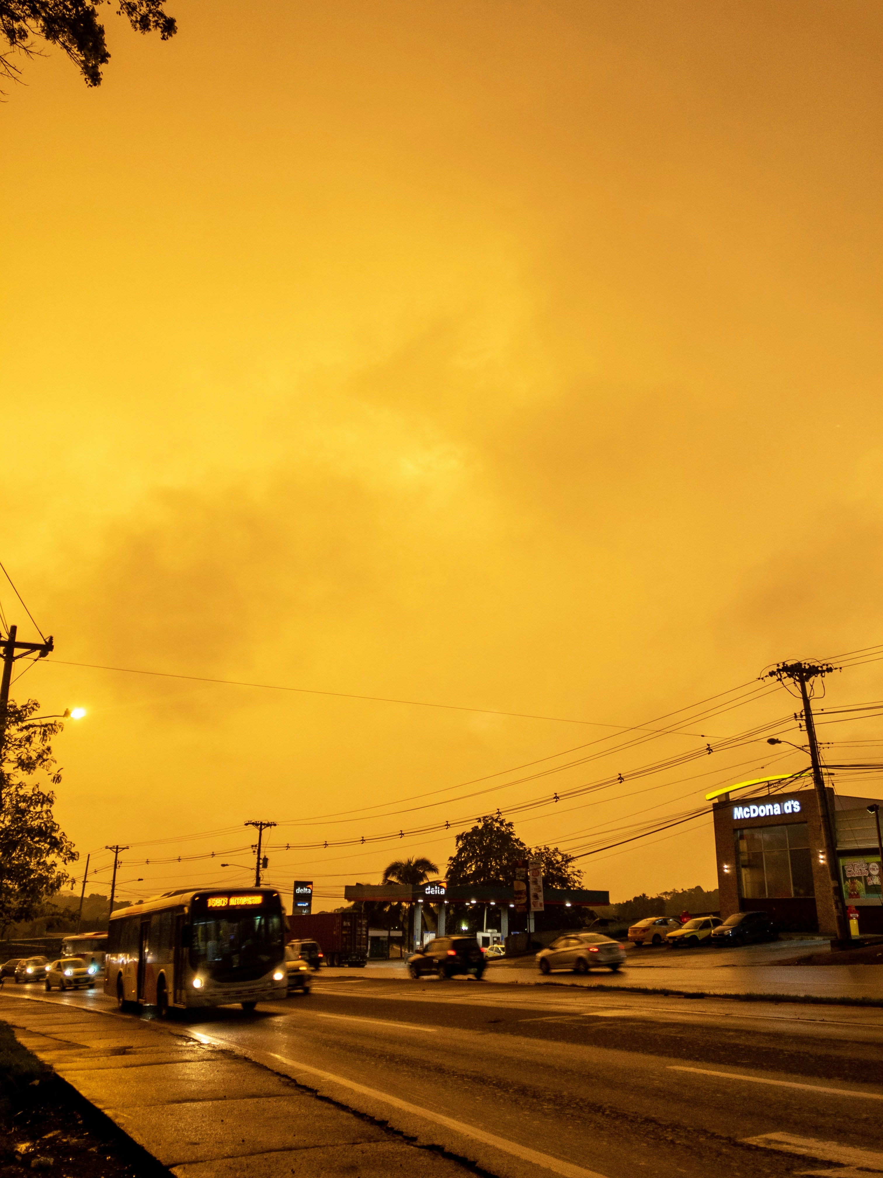 cars and buses traveling on highway under yellow sunset sky
