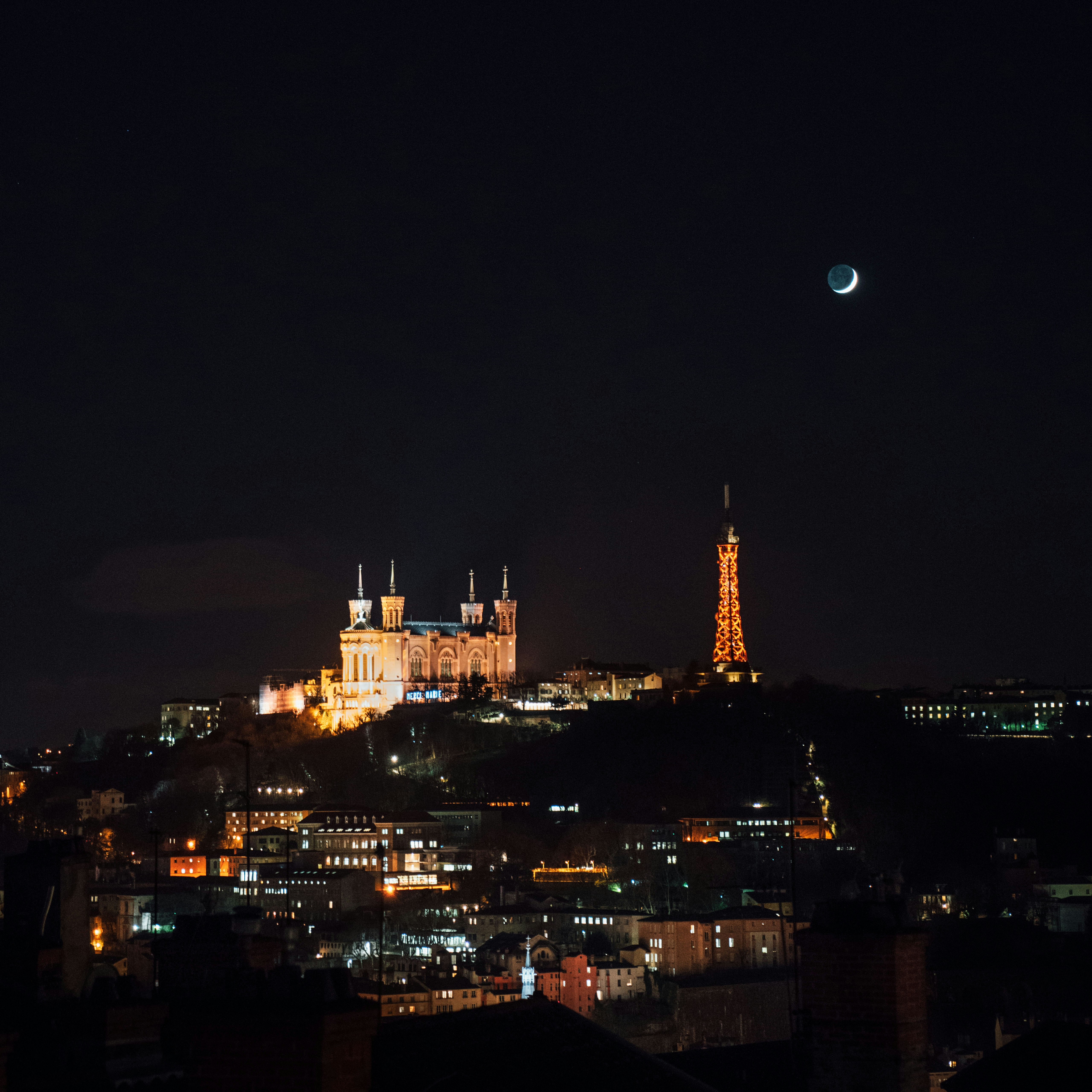 Crescent Moon Over Lanterned Cathedral: Night Cityscape on a Hill