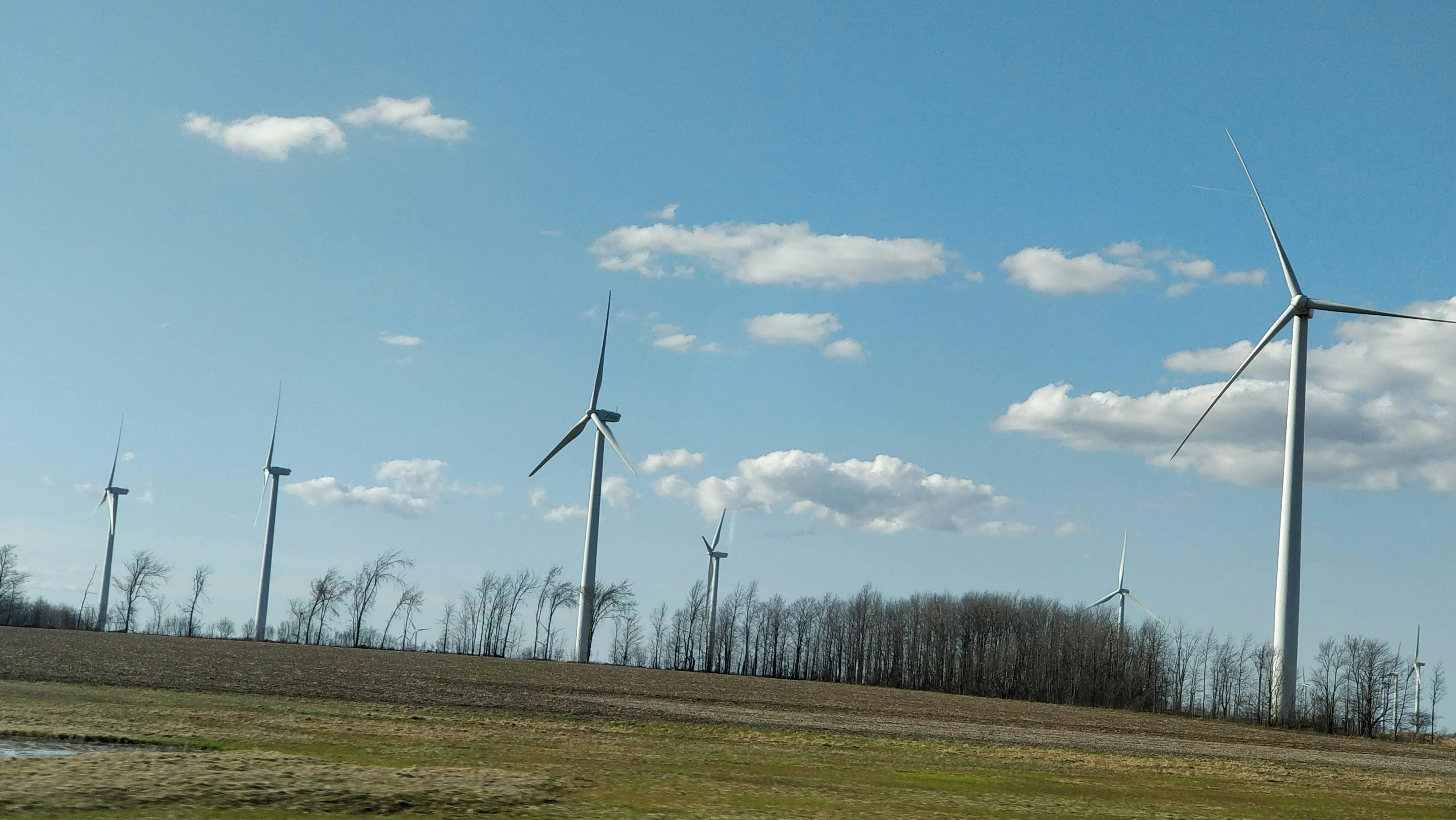 Horizon of Turbines: A Quiet Field Under a Cloud-Dotted Sky