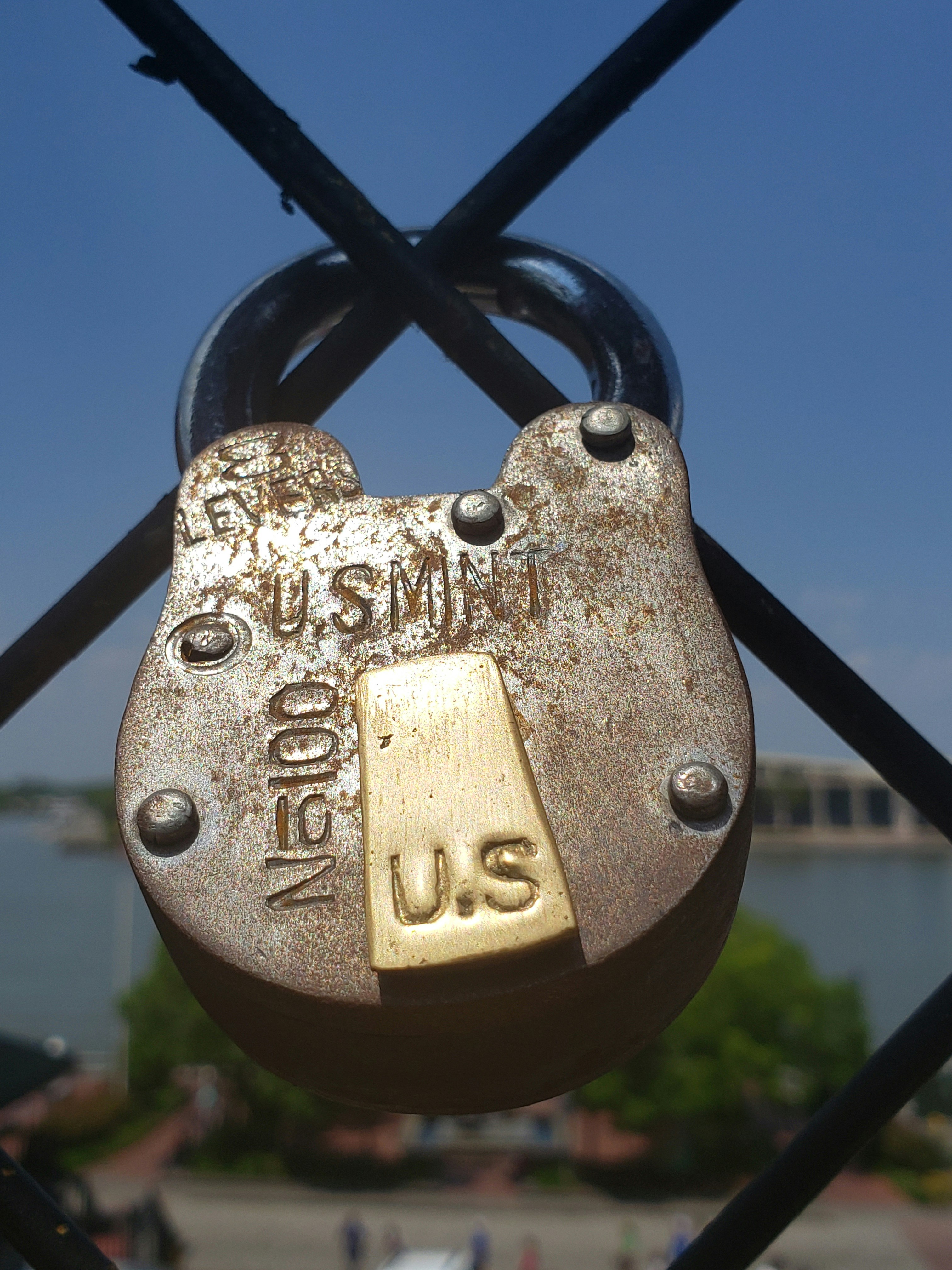 Rusted Sentinel Over the River: A Close-Up on a Waterfront Padlock