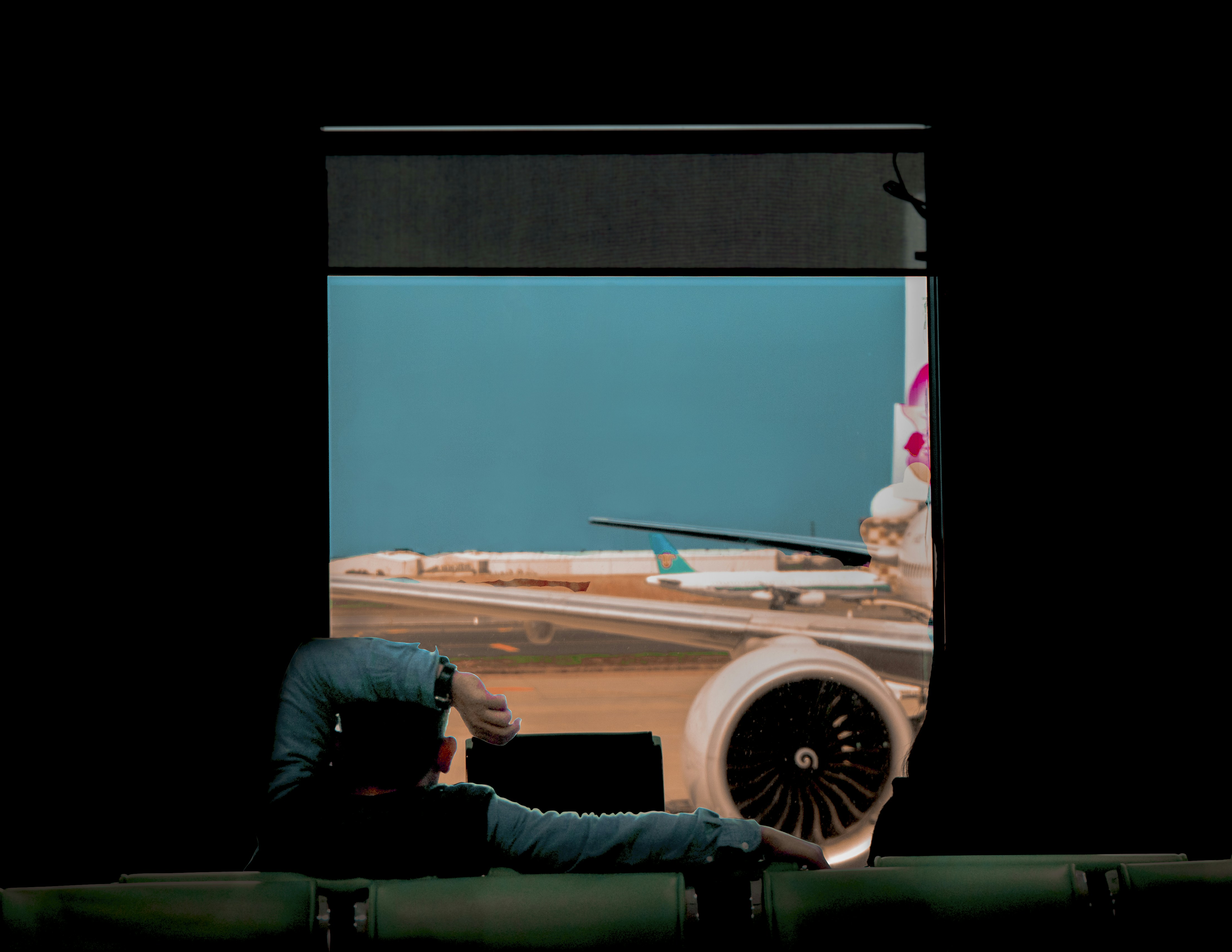 Windowframe Gaze: Teal Sky and Turbine through a Terminal Window