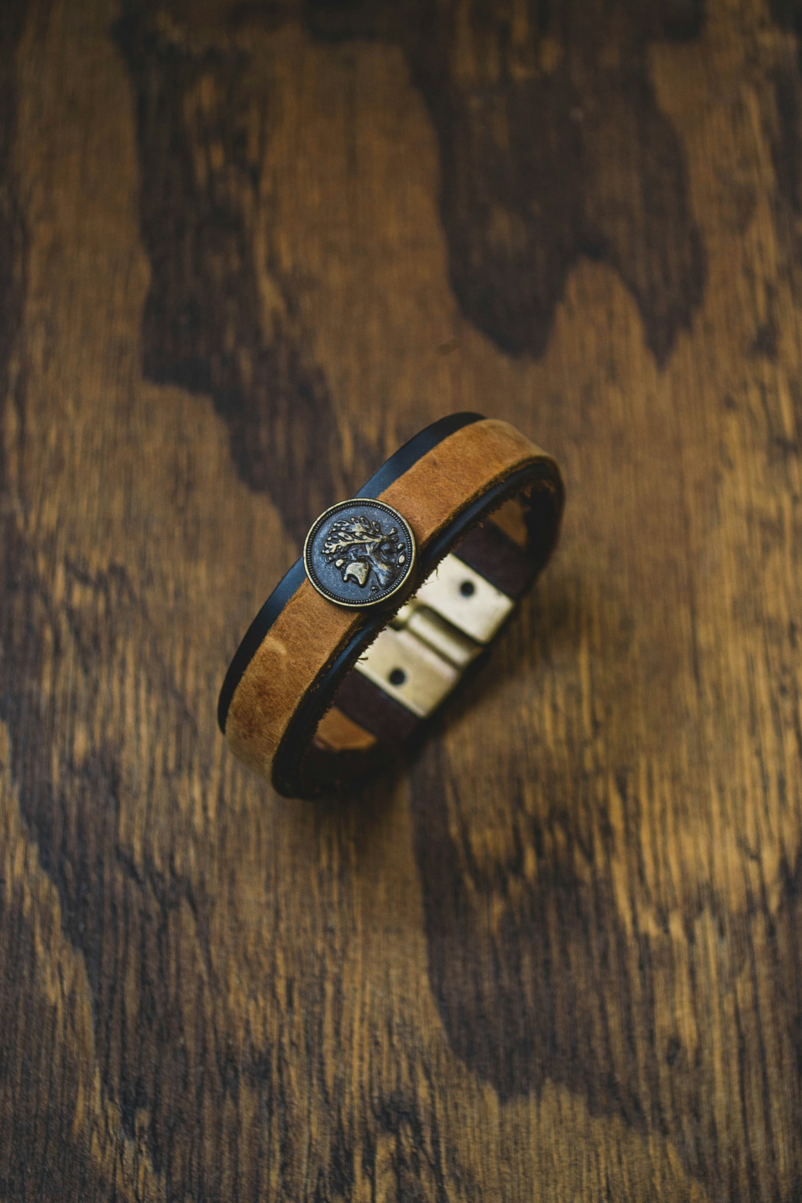 brown and black bracelet on brown wooden surface