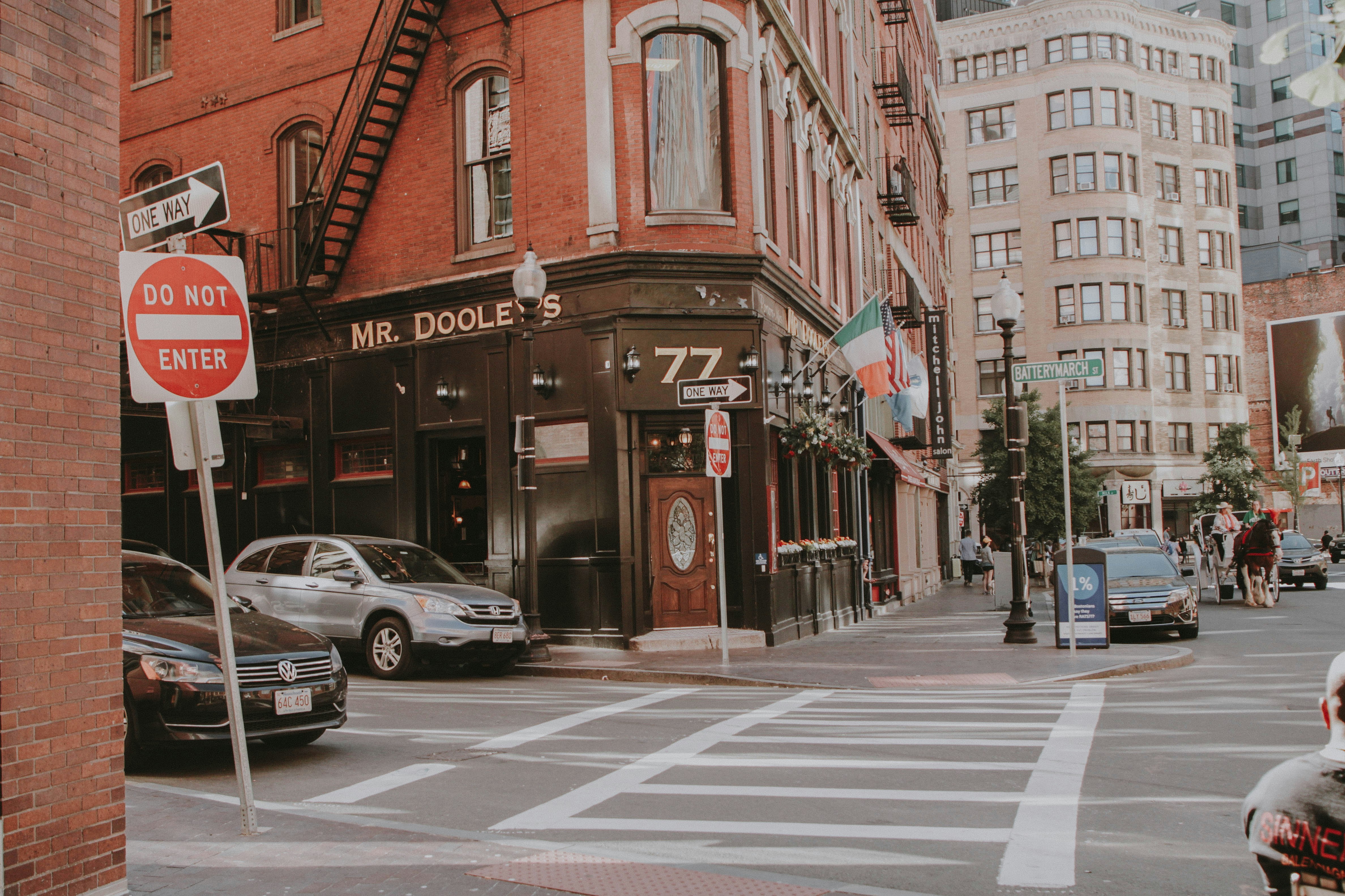 City intersection with red brick buildings and a pedestrian lane under soft daylight.
