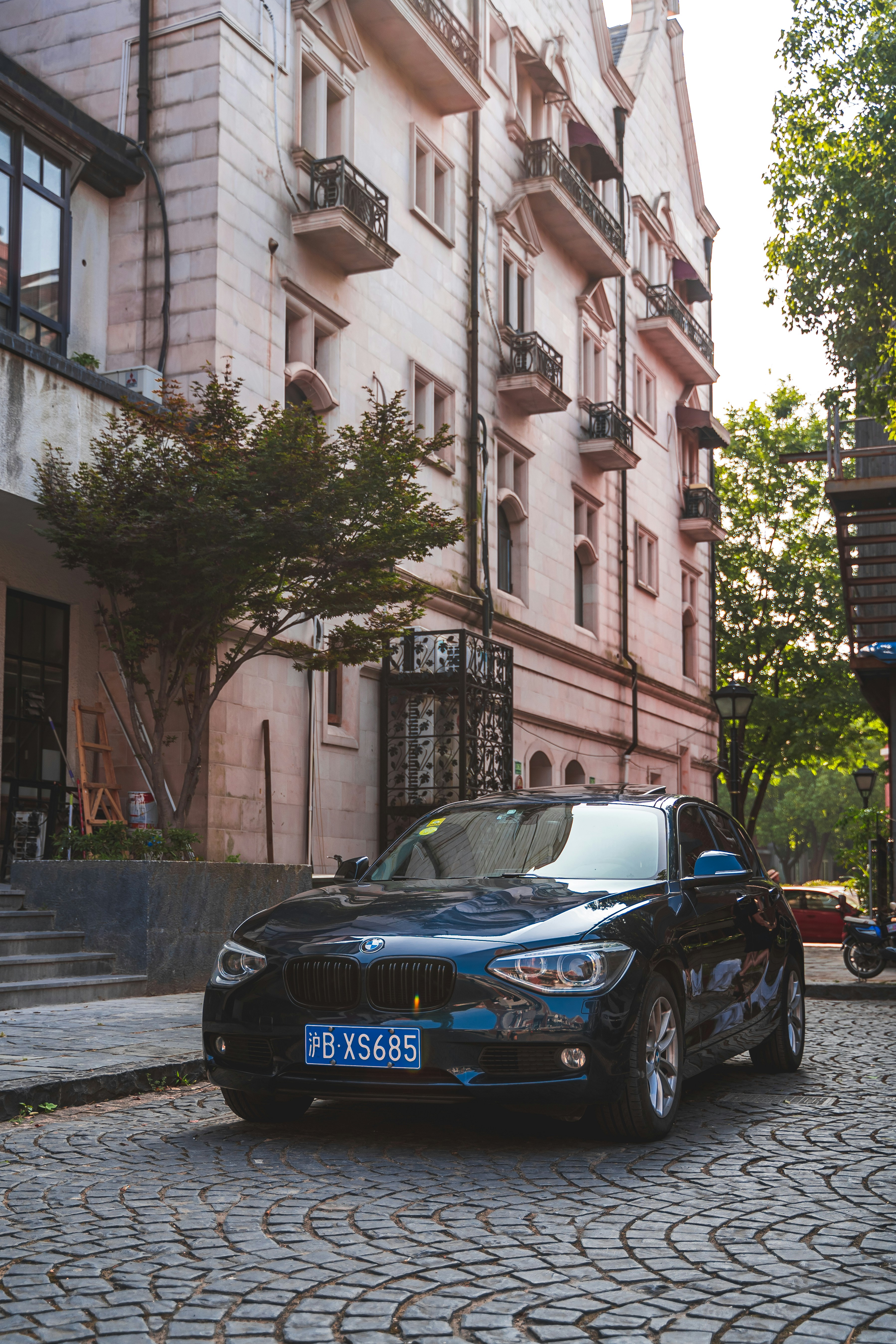 Blue BMW in a Cobblestone Urban Corridor