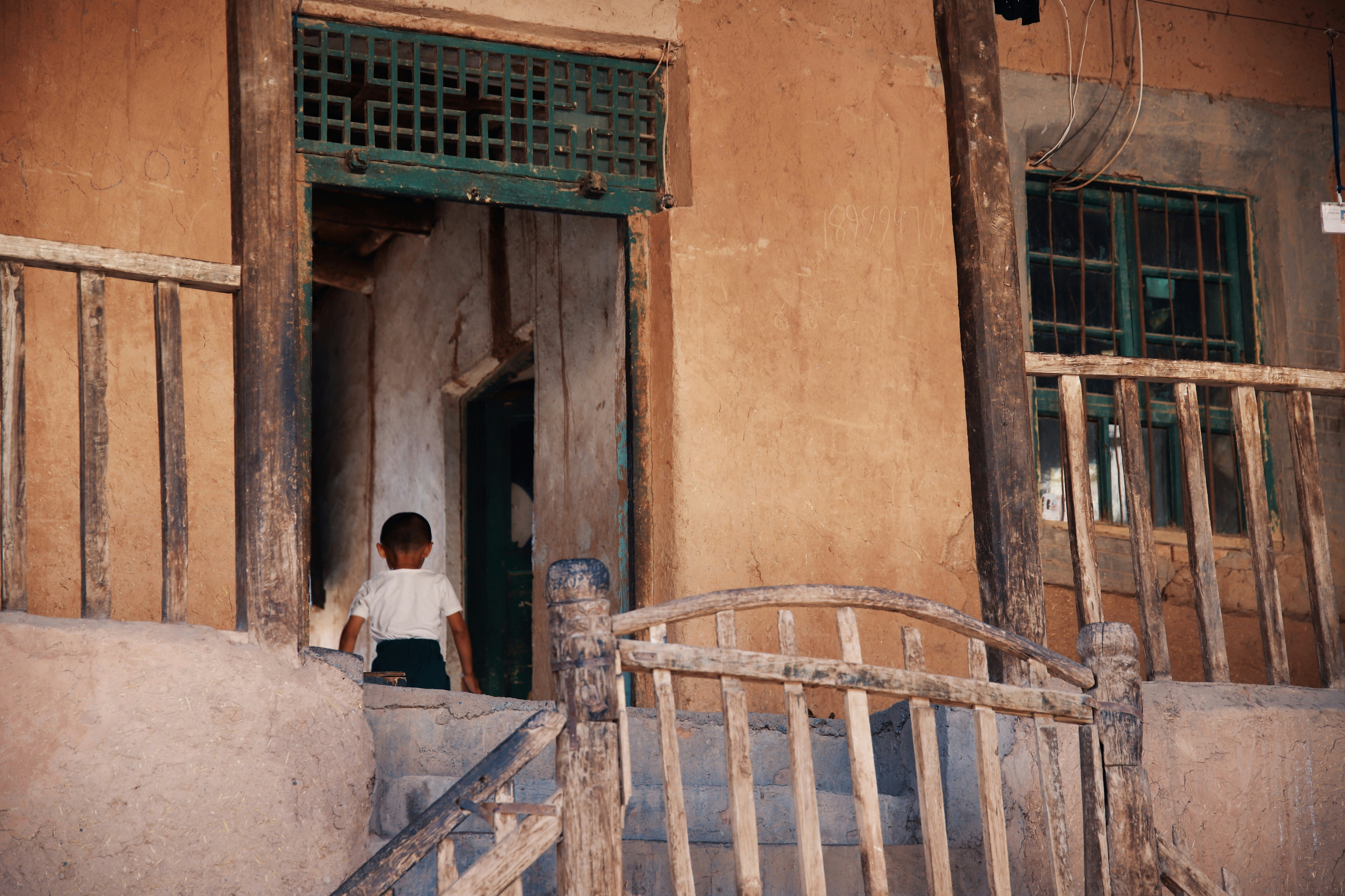 Boy in white shirt and black bottoms standing inside house photo – Free ...