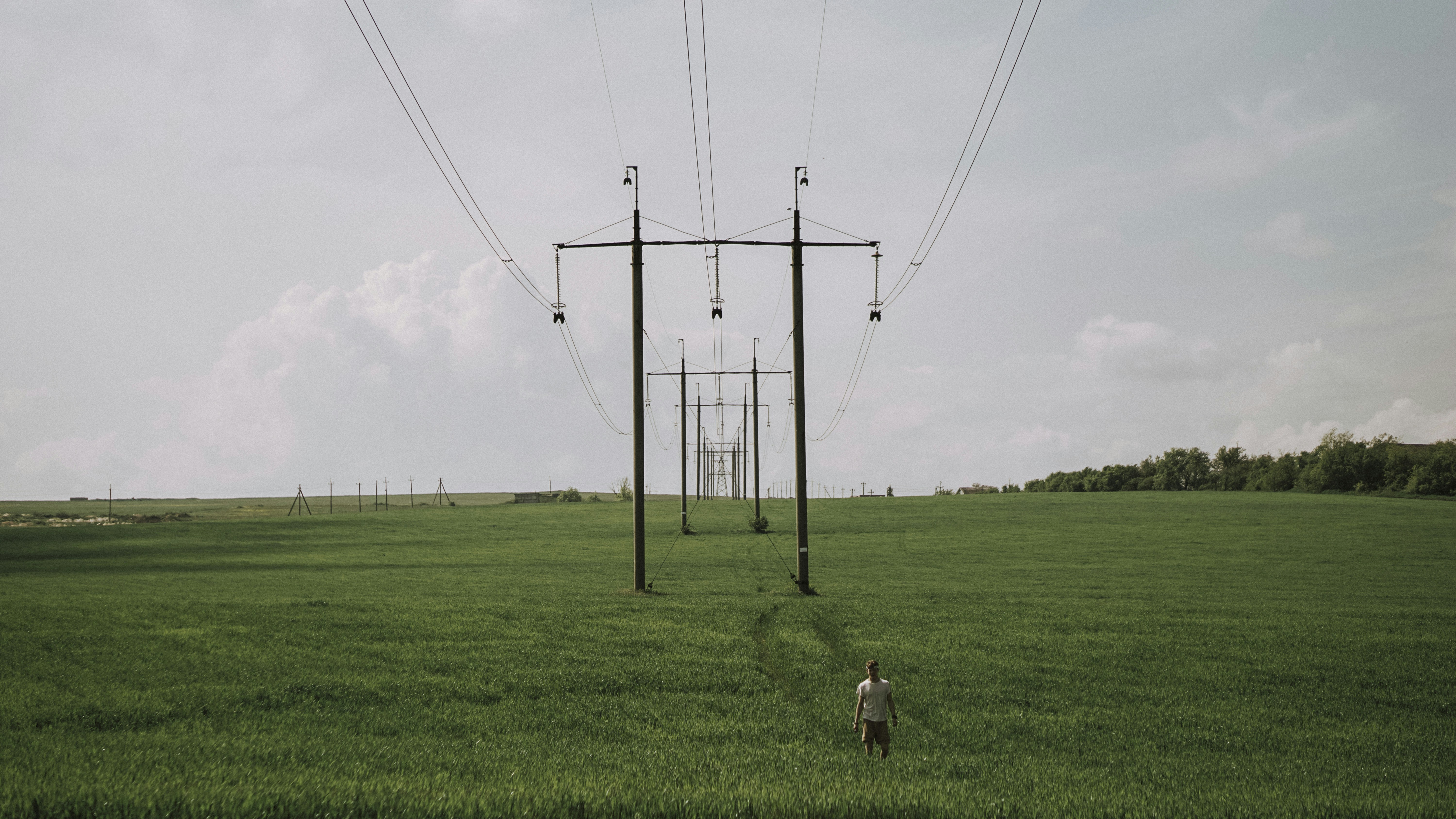 Footstep on a Vast Prairie Beneath a Corridor of Transmission Towers