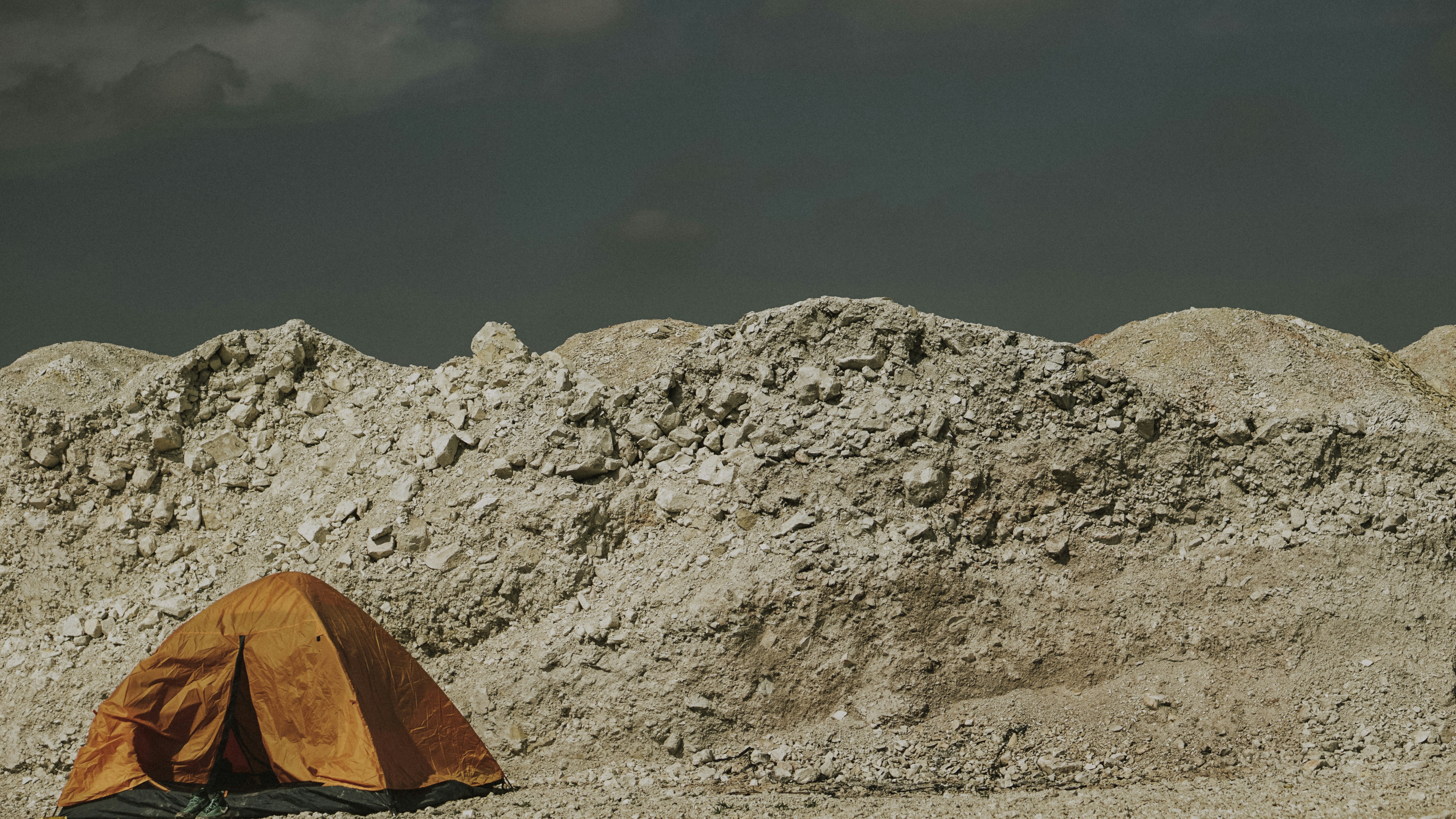 Orange Shelter at the Edge of a Rugged Quarry