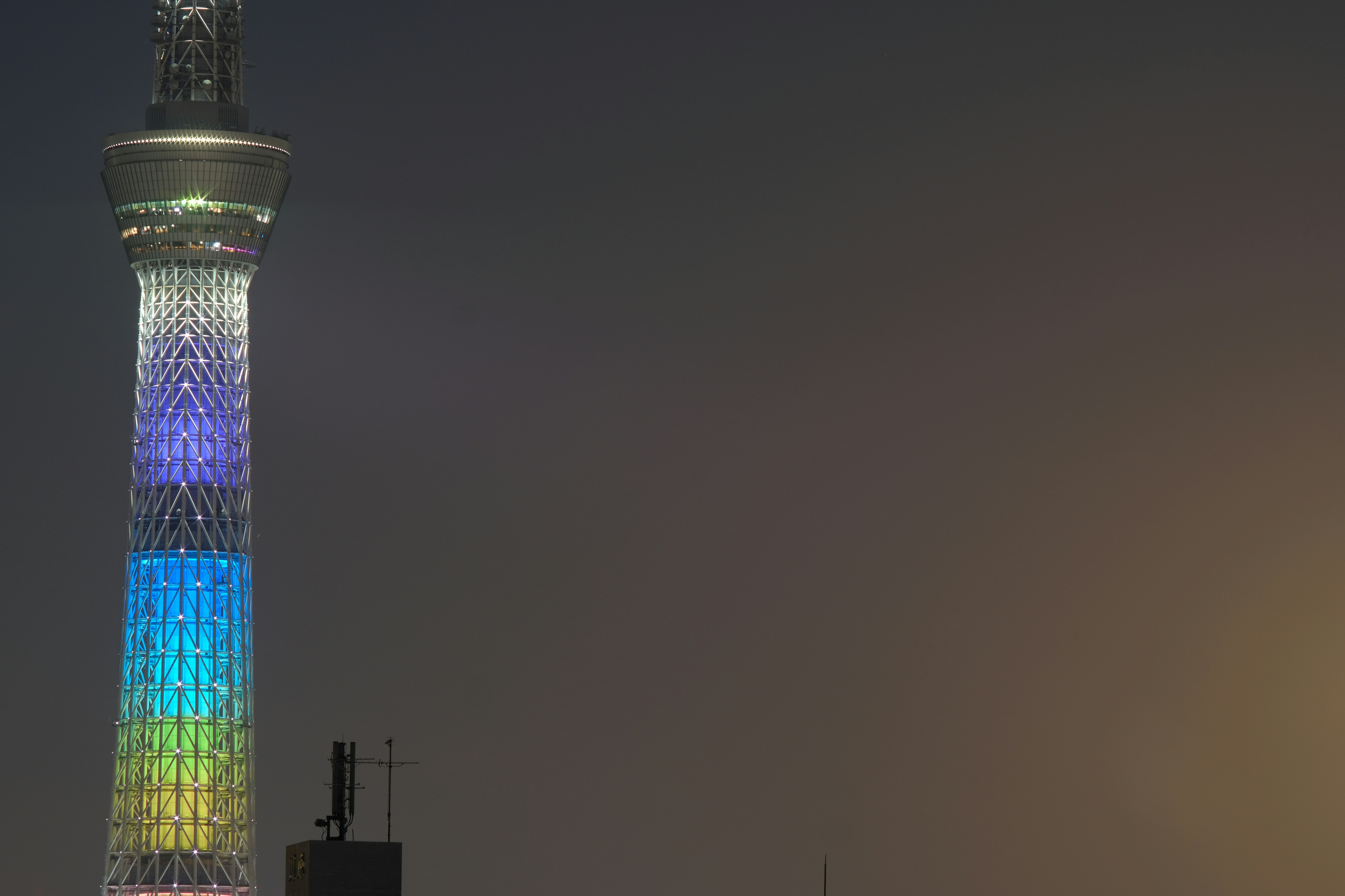 Rainbow-Tinted Tower Pierces the Night Sky
